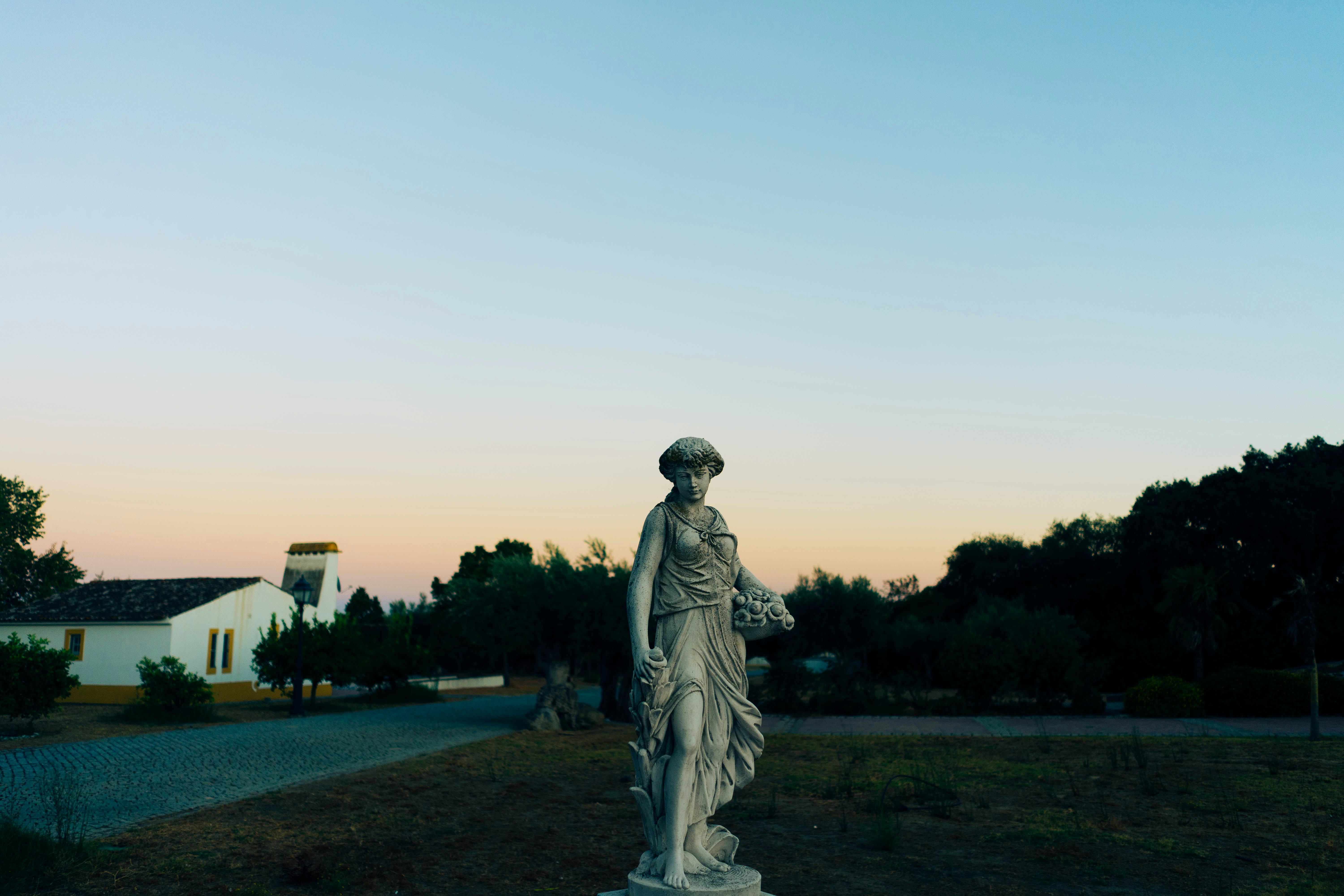 Statue at Dusk: A Quiet Promenade Under an Open Sky