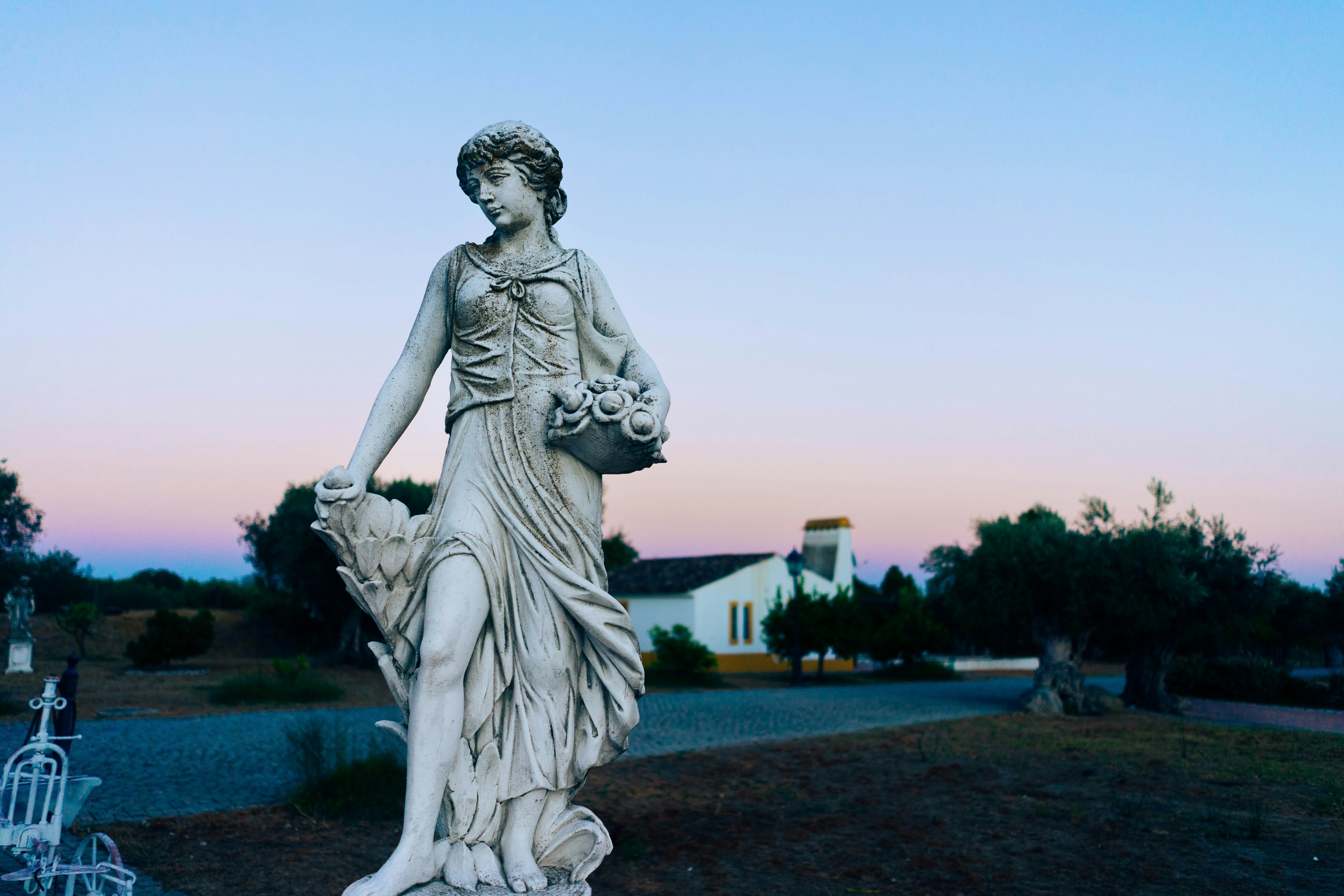 Statue of Grace Beneath a Sunset Sky