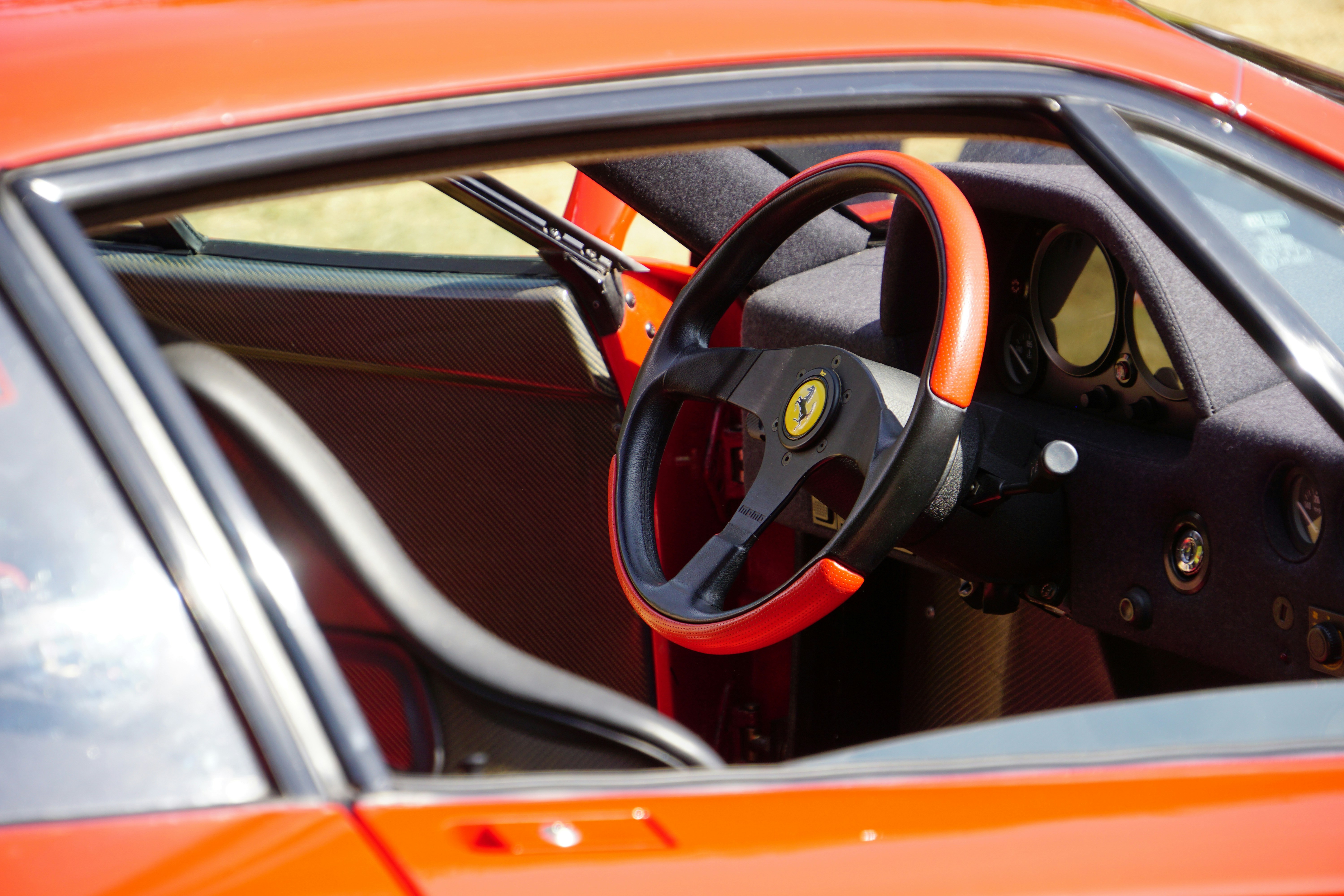Ferrari cockpit glimpse: red accents and circular steering hub