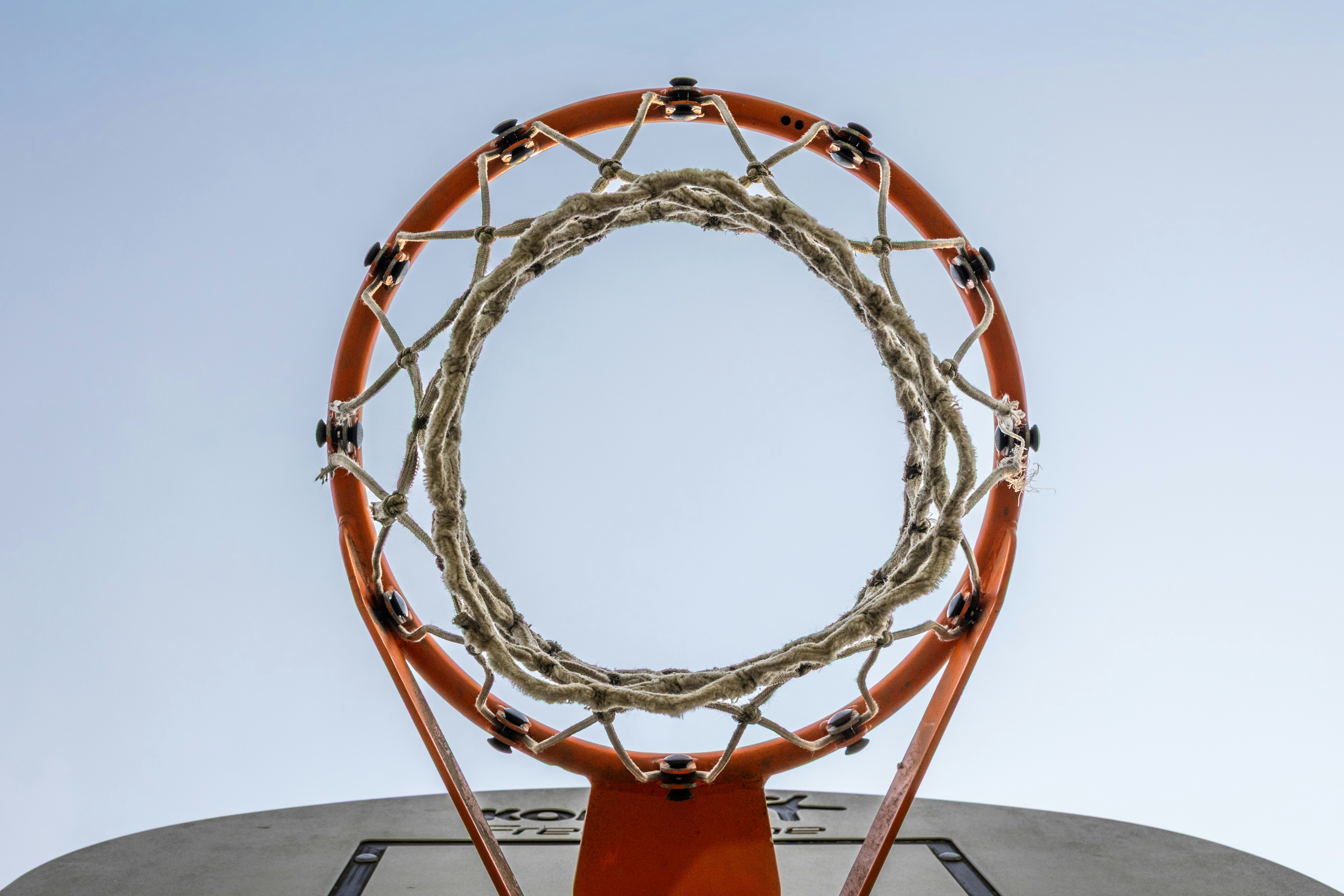 High Hoop in Clear Sky: A Close-up of the Net and Rim from Below