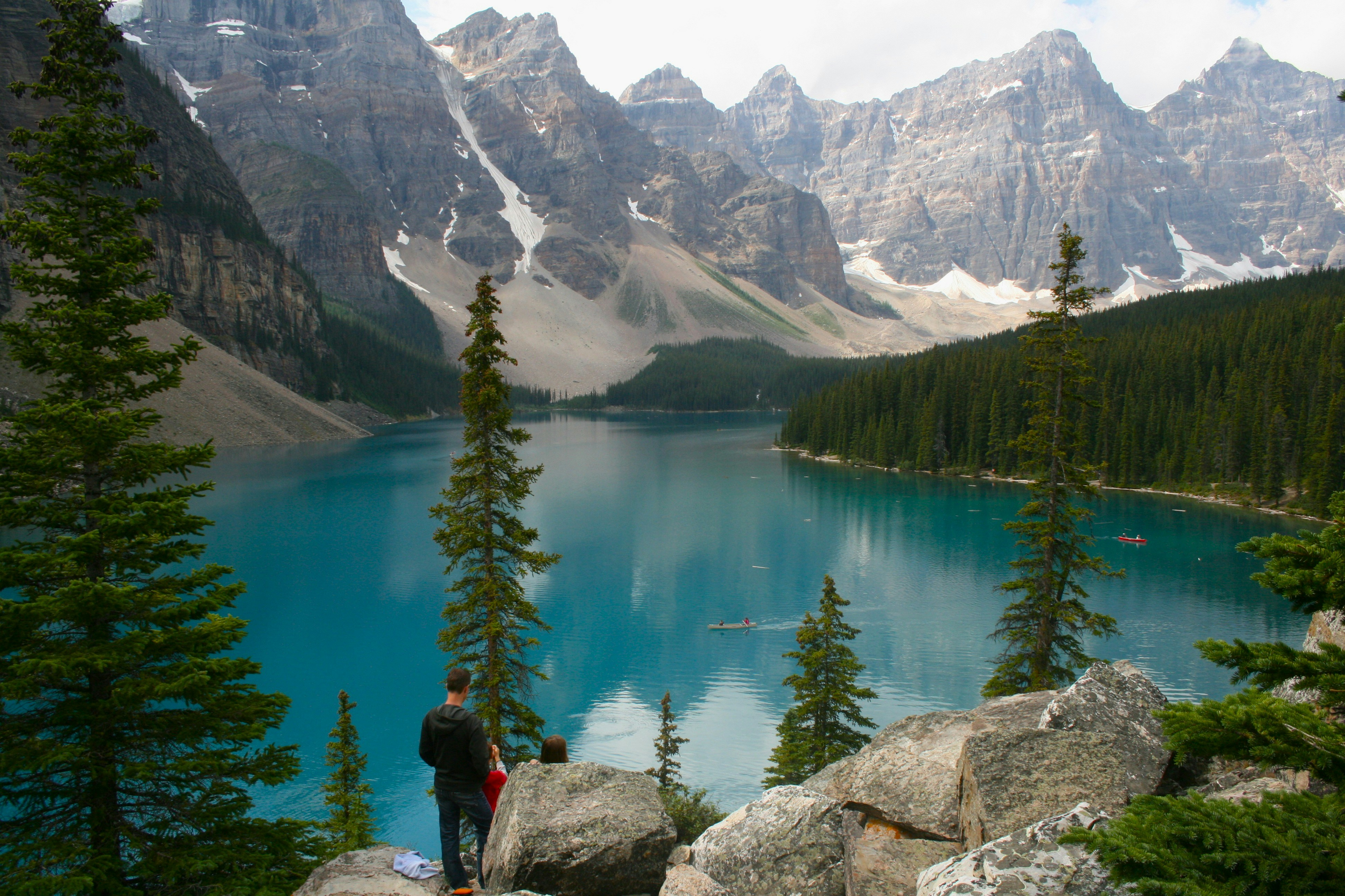 Lakeside Sentinel: A Pair of Hikers Beneath Alpine Giants