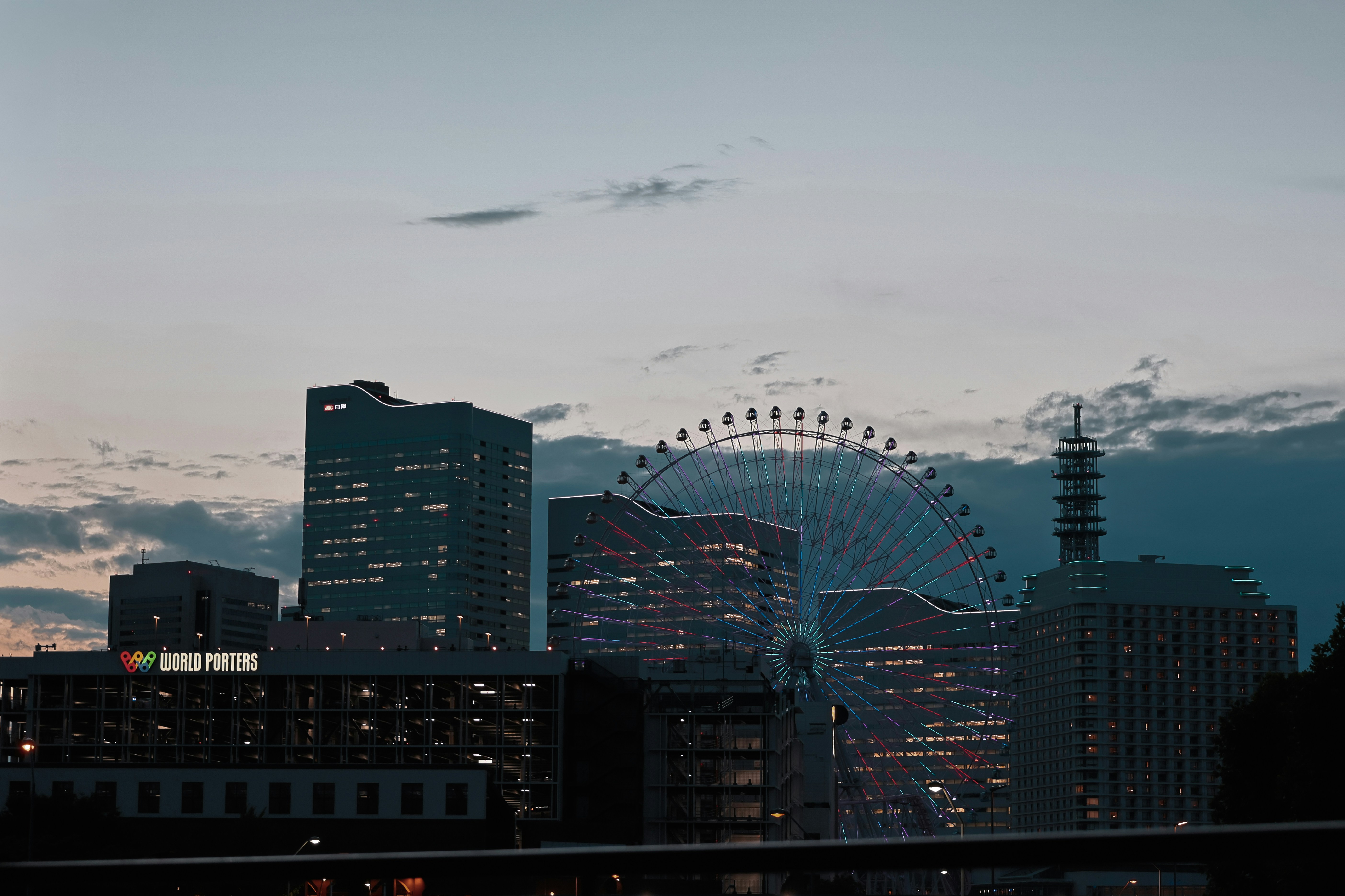 City Lights Beyond the Ring: Evening Skyline and Ferris Wheel