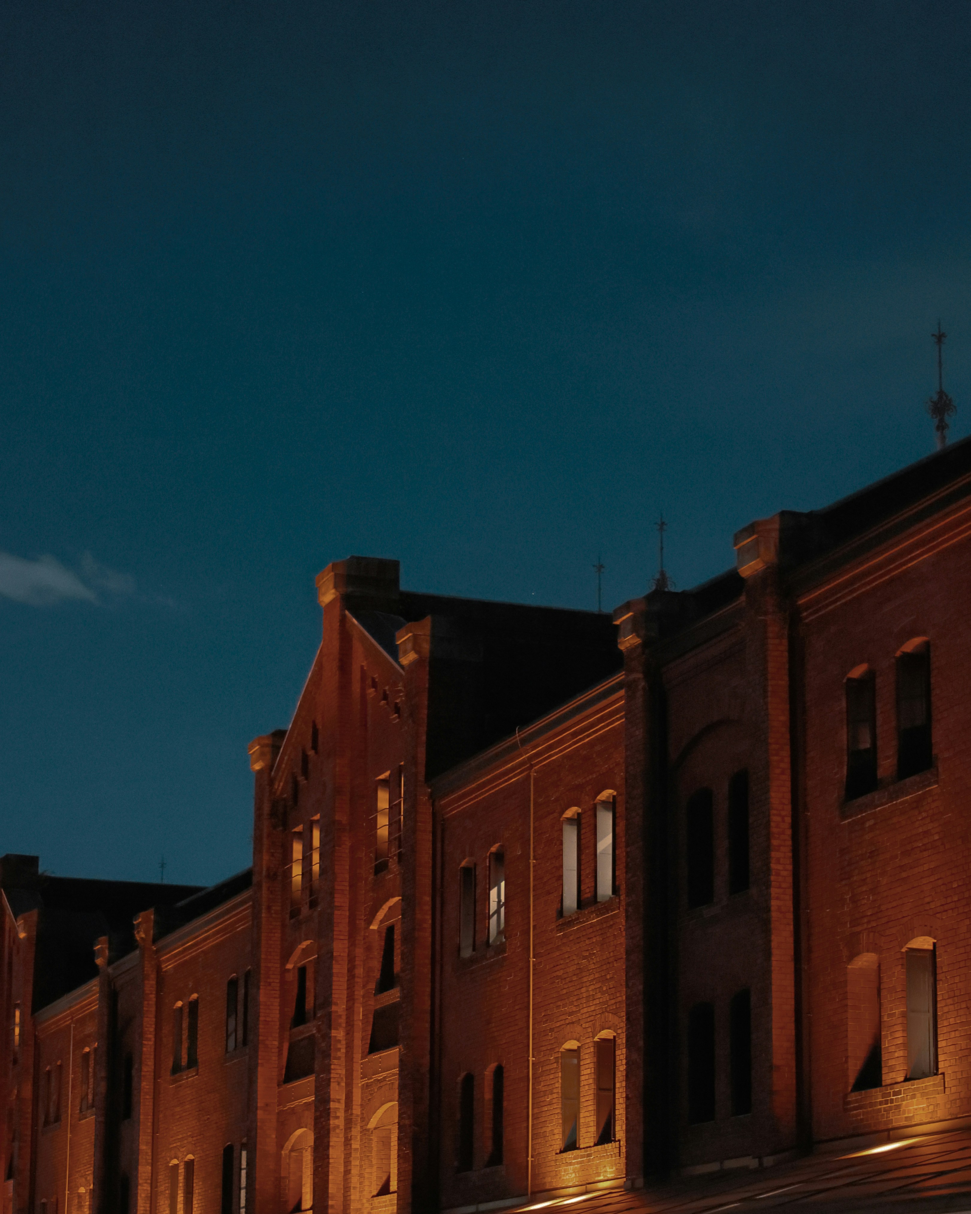 Brick Facade at Dusk: A Row of Illuminated Windows Against a Velvet Sky