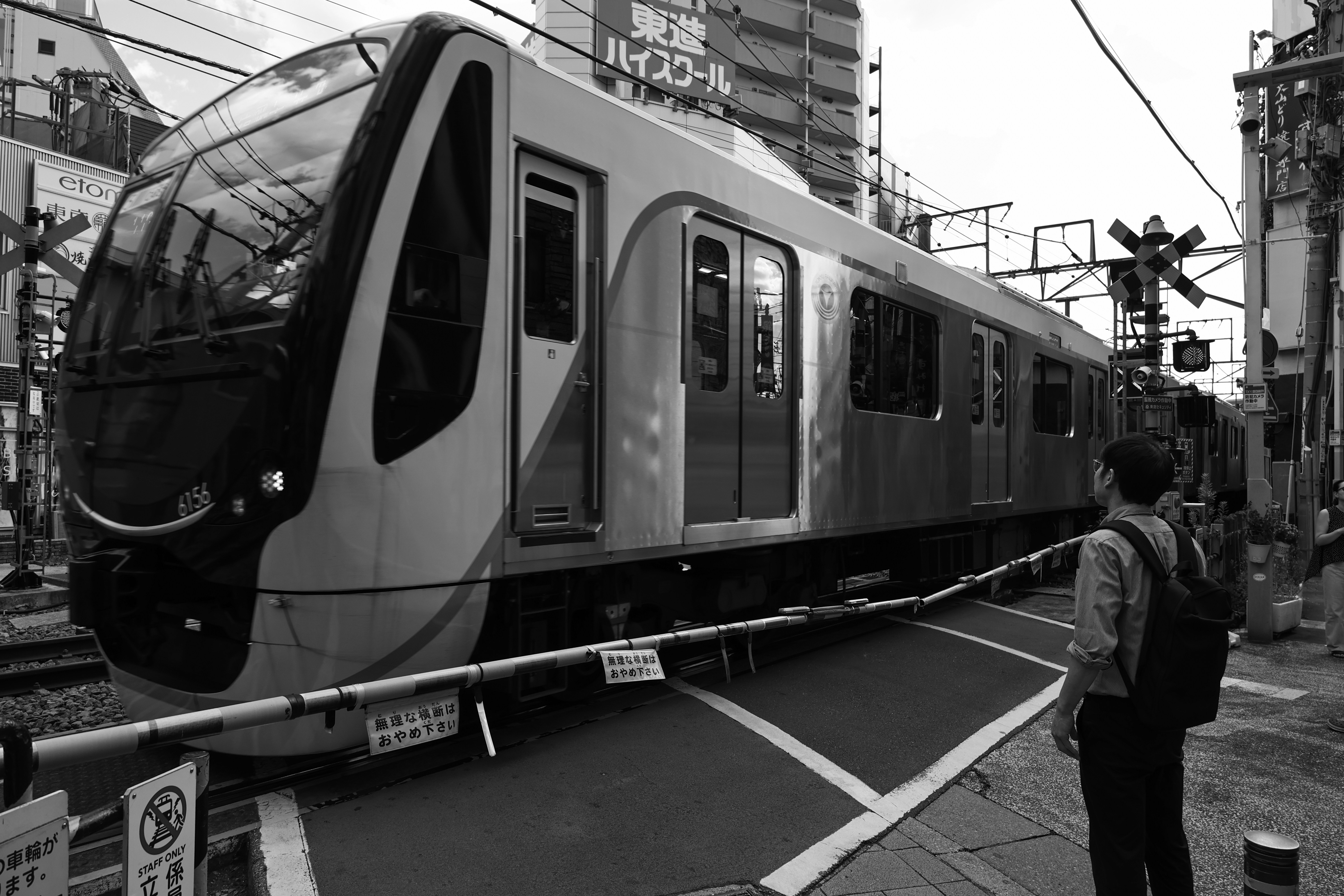 Urban Crossing: A Passenger Faces the Metro at a Japanese Rail Stop