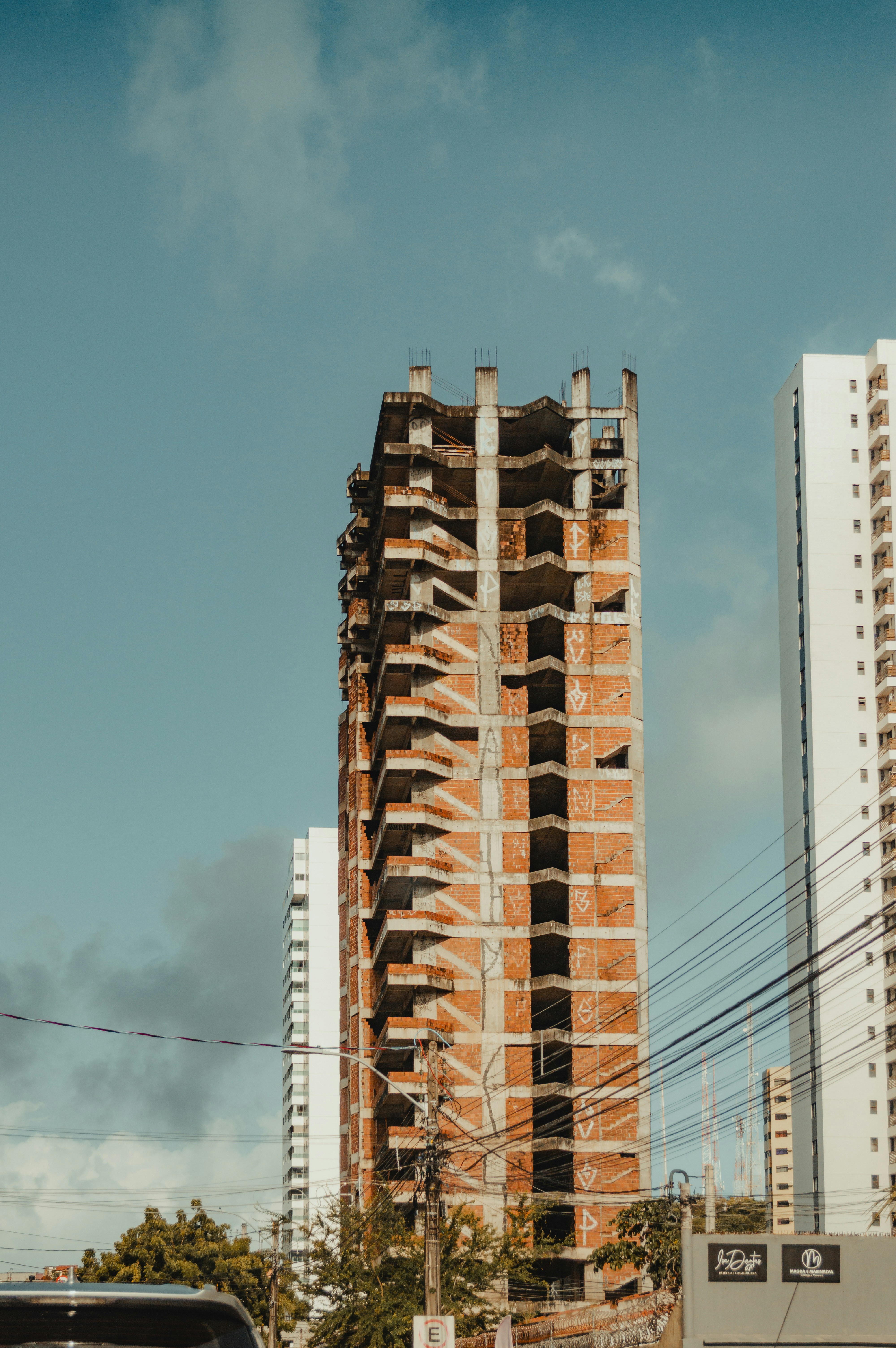 Concrete Skeleton Reaching Skyward: A Partially Built Tower Among Quiet Urban Sprawl
