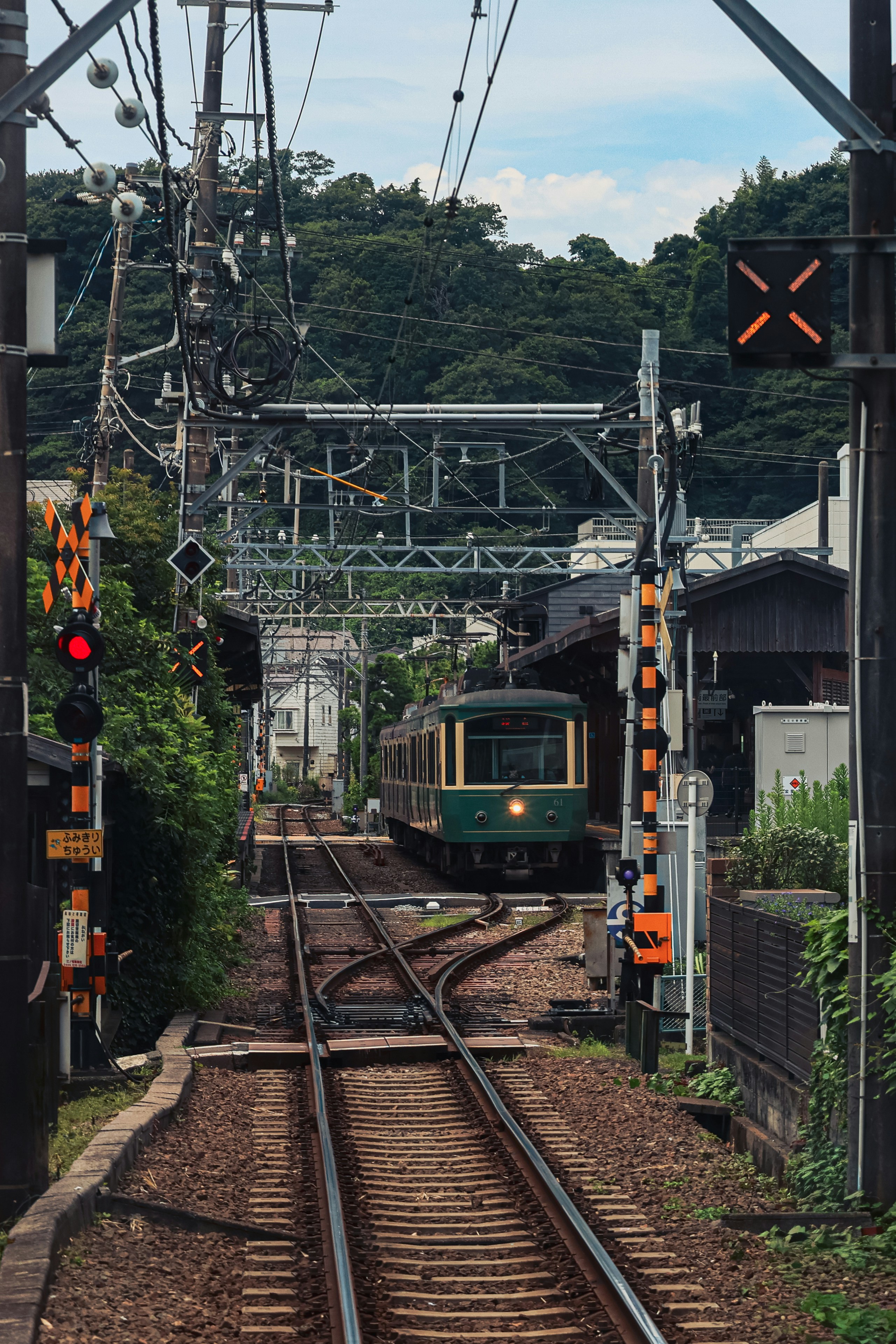 Rails at Dawn: A Green Train Winds Through a Quiet Japanese Town