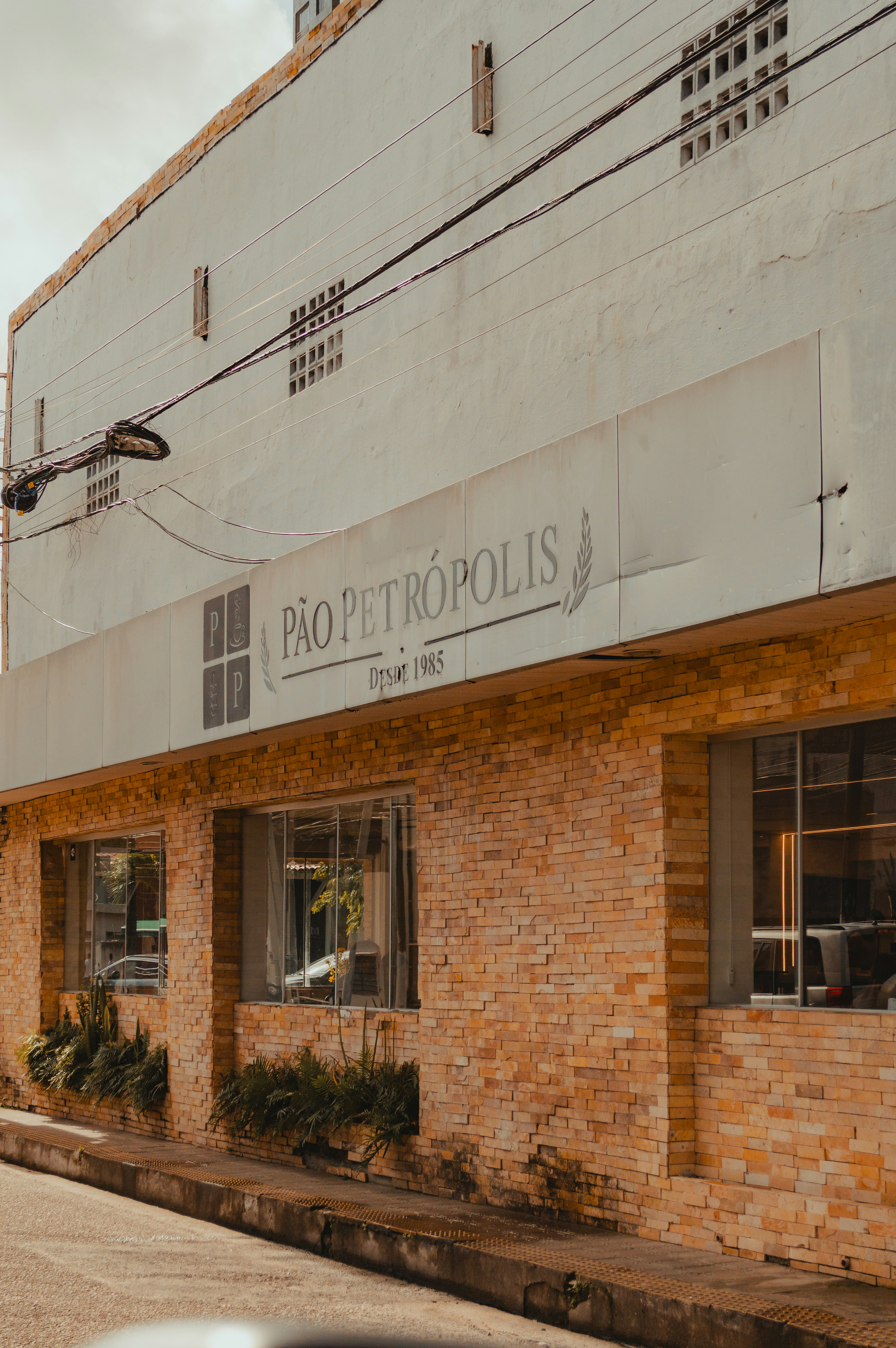 Petropolis Signage on Brick Facade Under Gentle Street Light