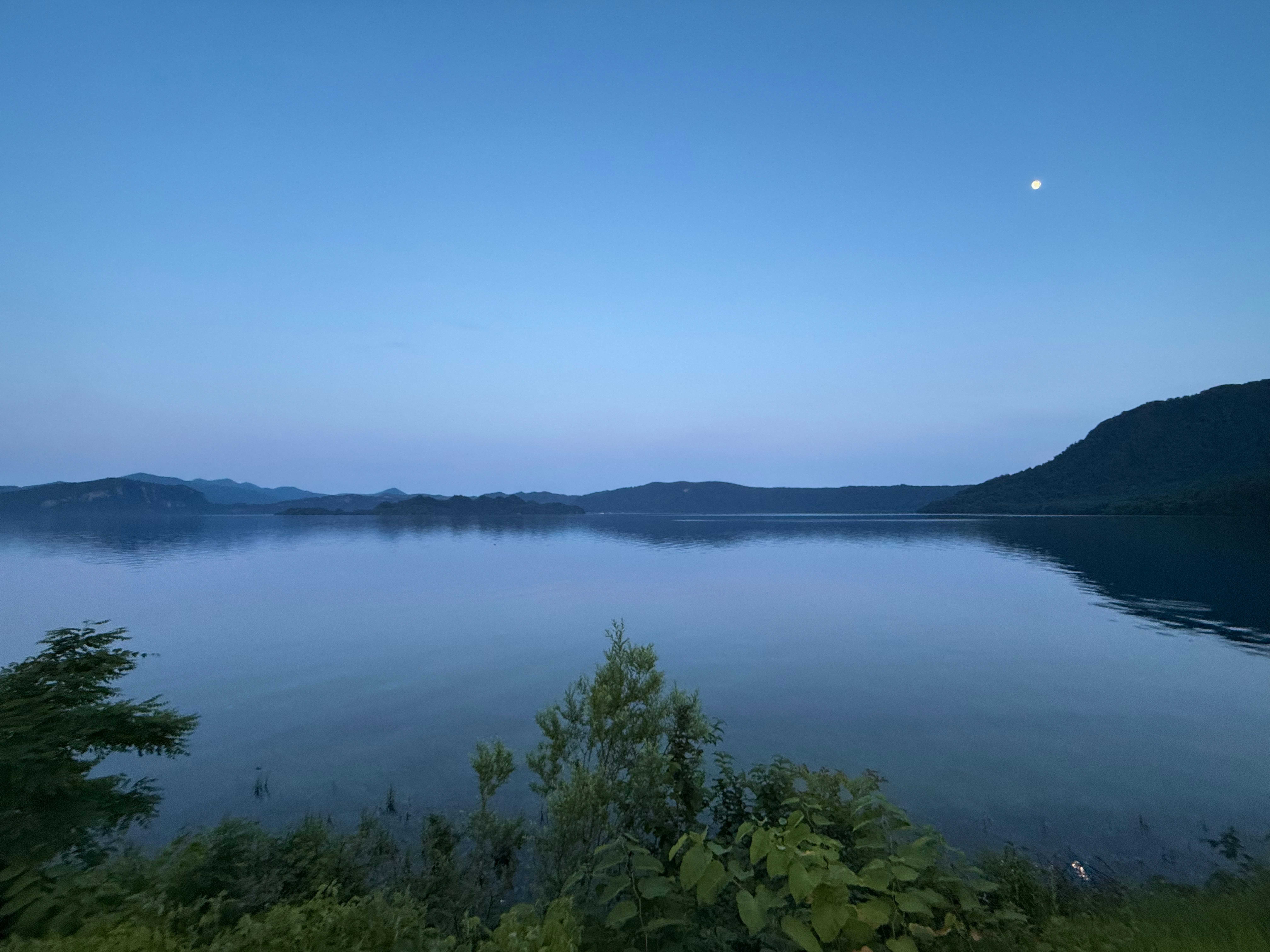 Serene Lake at Dusk: A Mirror of Hills and Sky