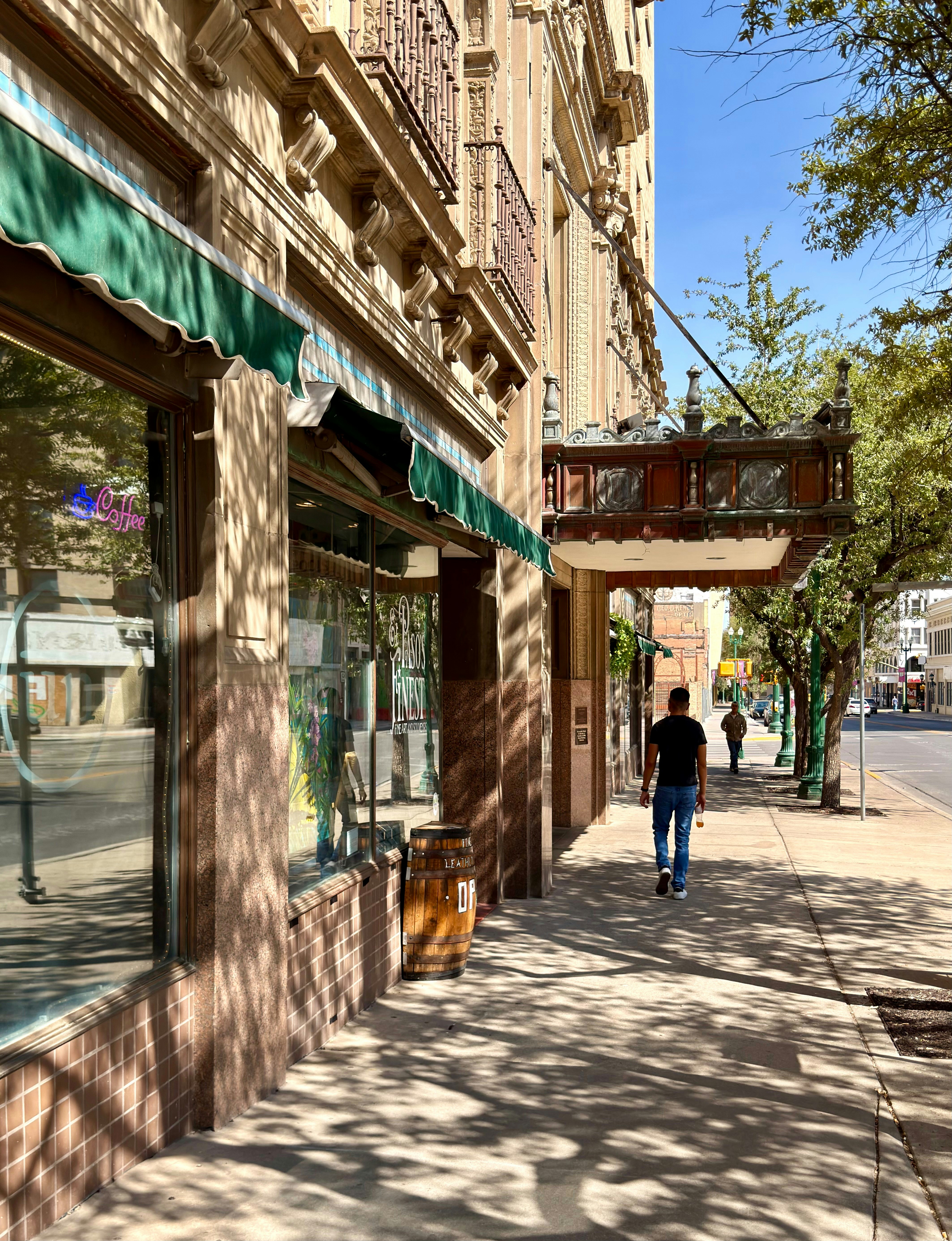 Sunlit Sidewalk Corridor Under Green Awnings