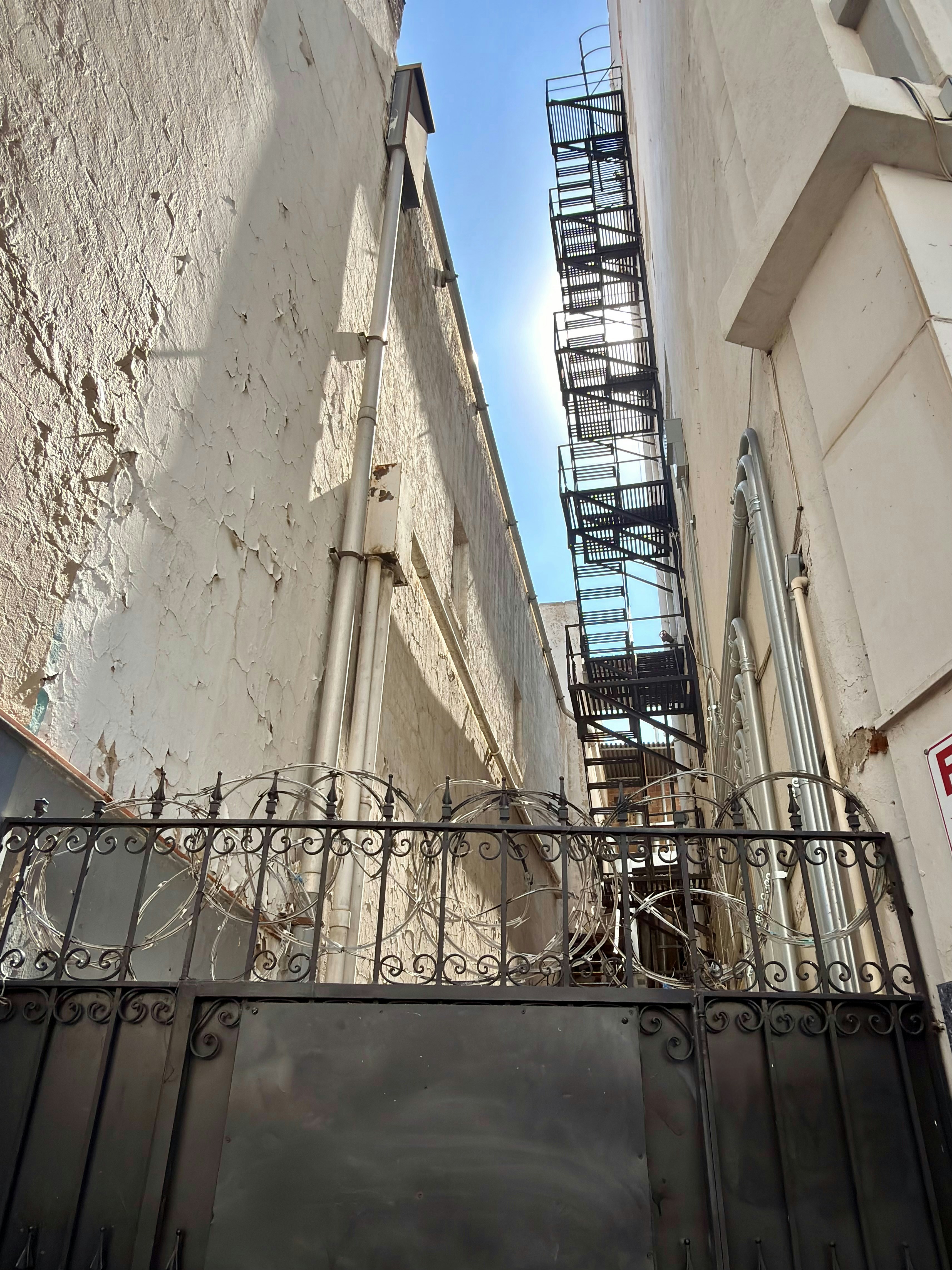 Climb of Steel: Narrow Alley with Fire Escape Silhouette