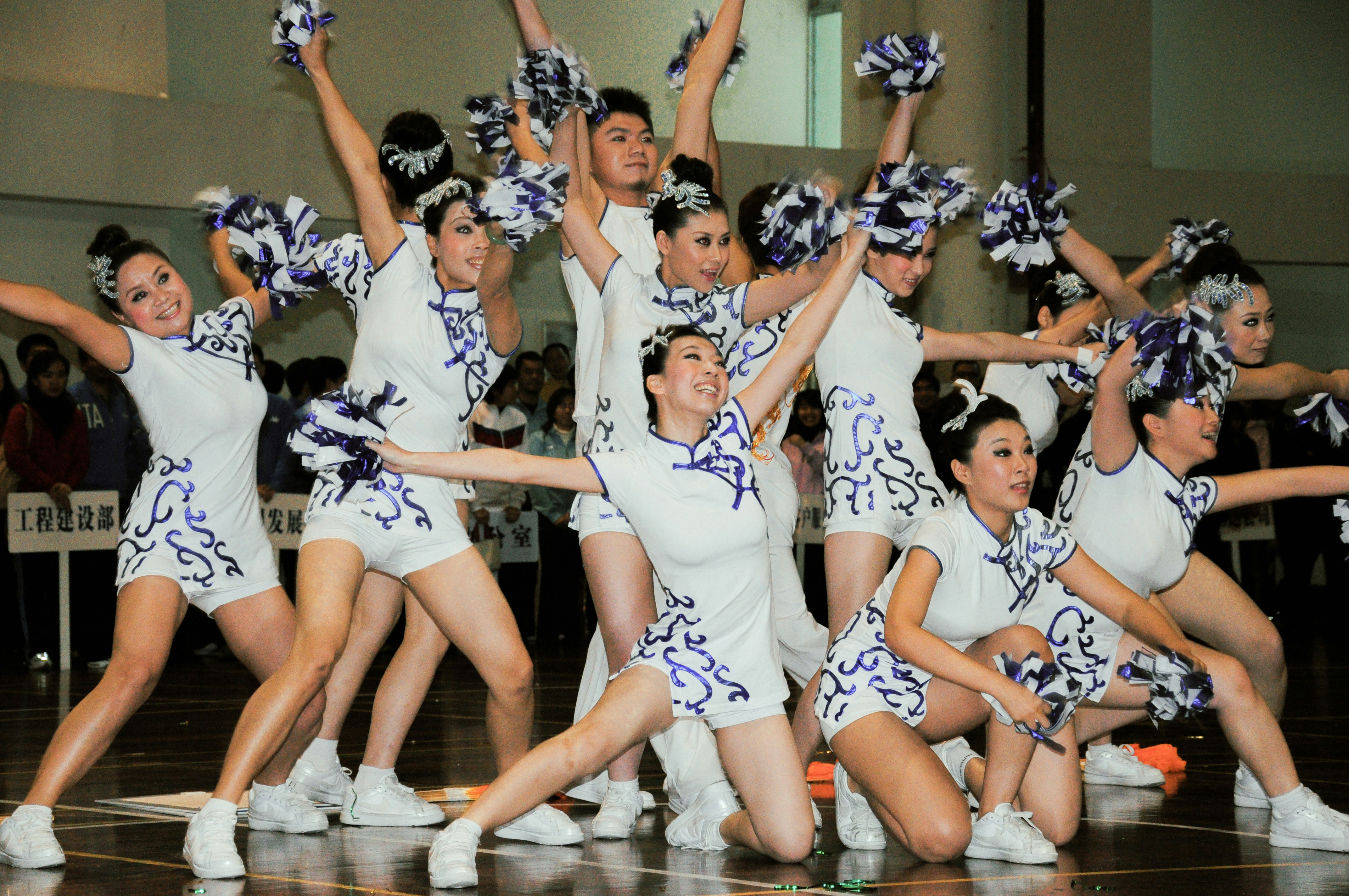 Fluid Synchrony: A Line of Cheerful Dancers in White and Purple