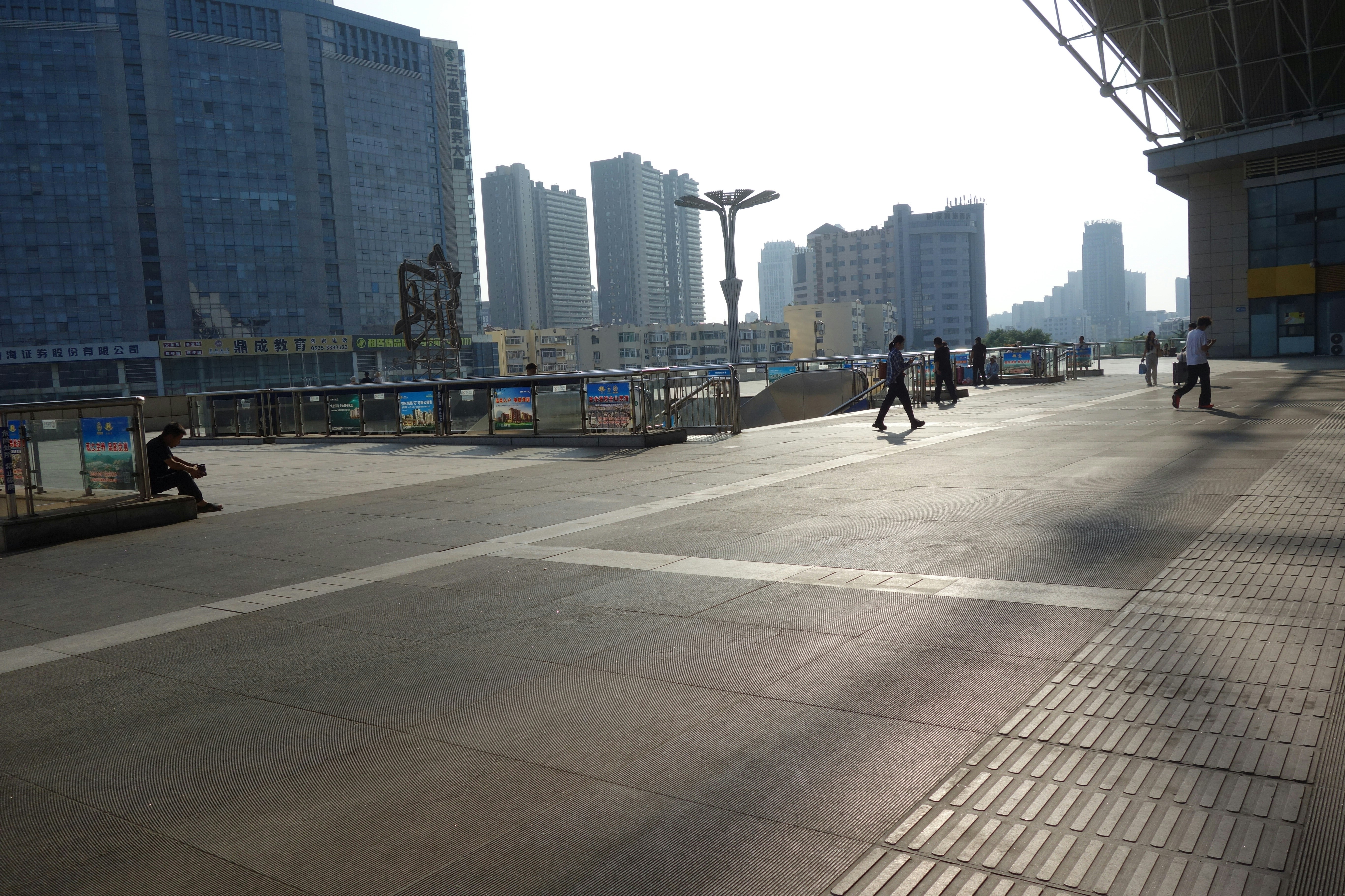 Morning Walkway under a Modern Arc: Shaded Steps and Distant Skyline