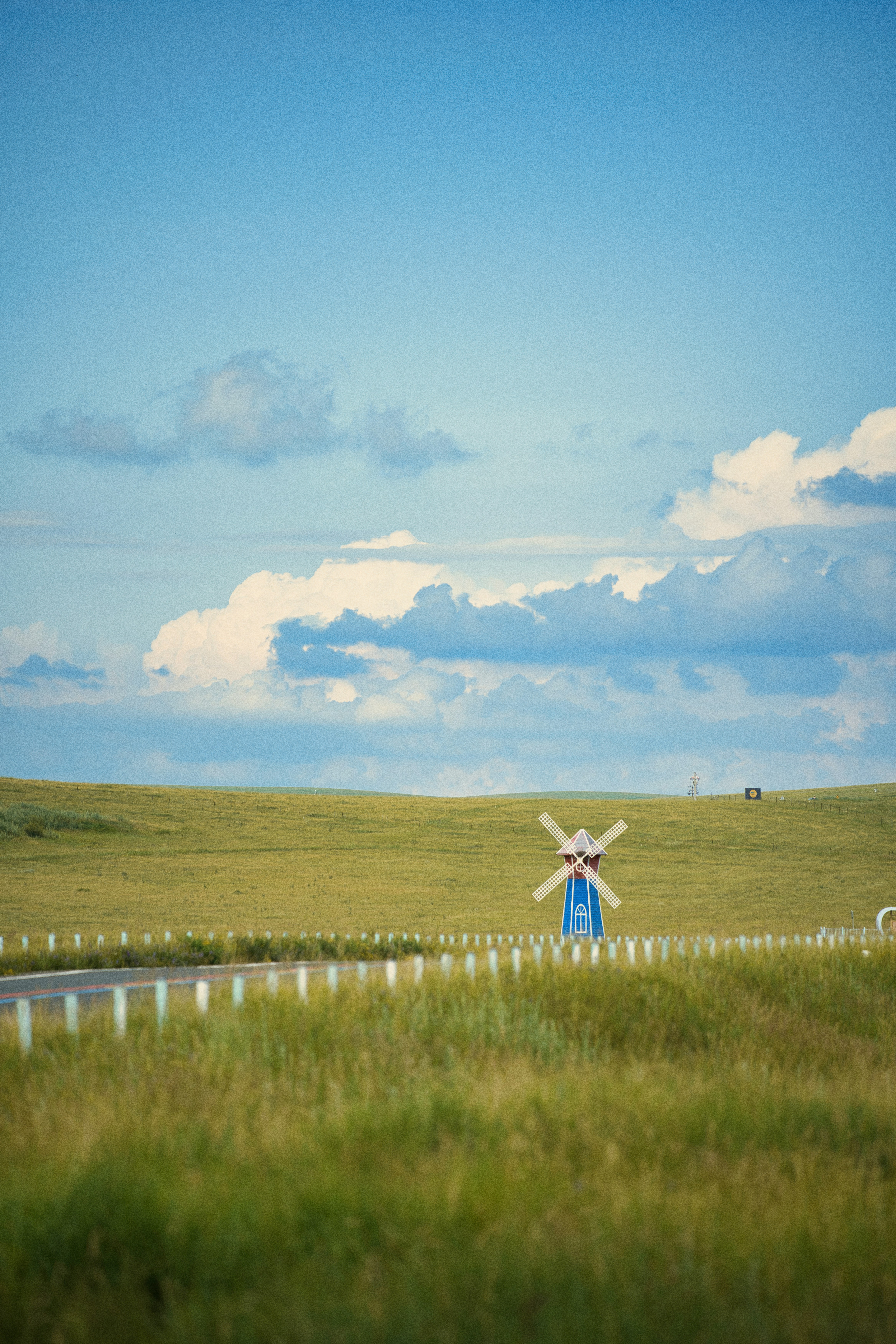 Rolling Grasslands Meet a Windmill Sentinel