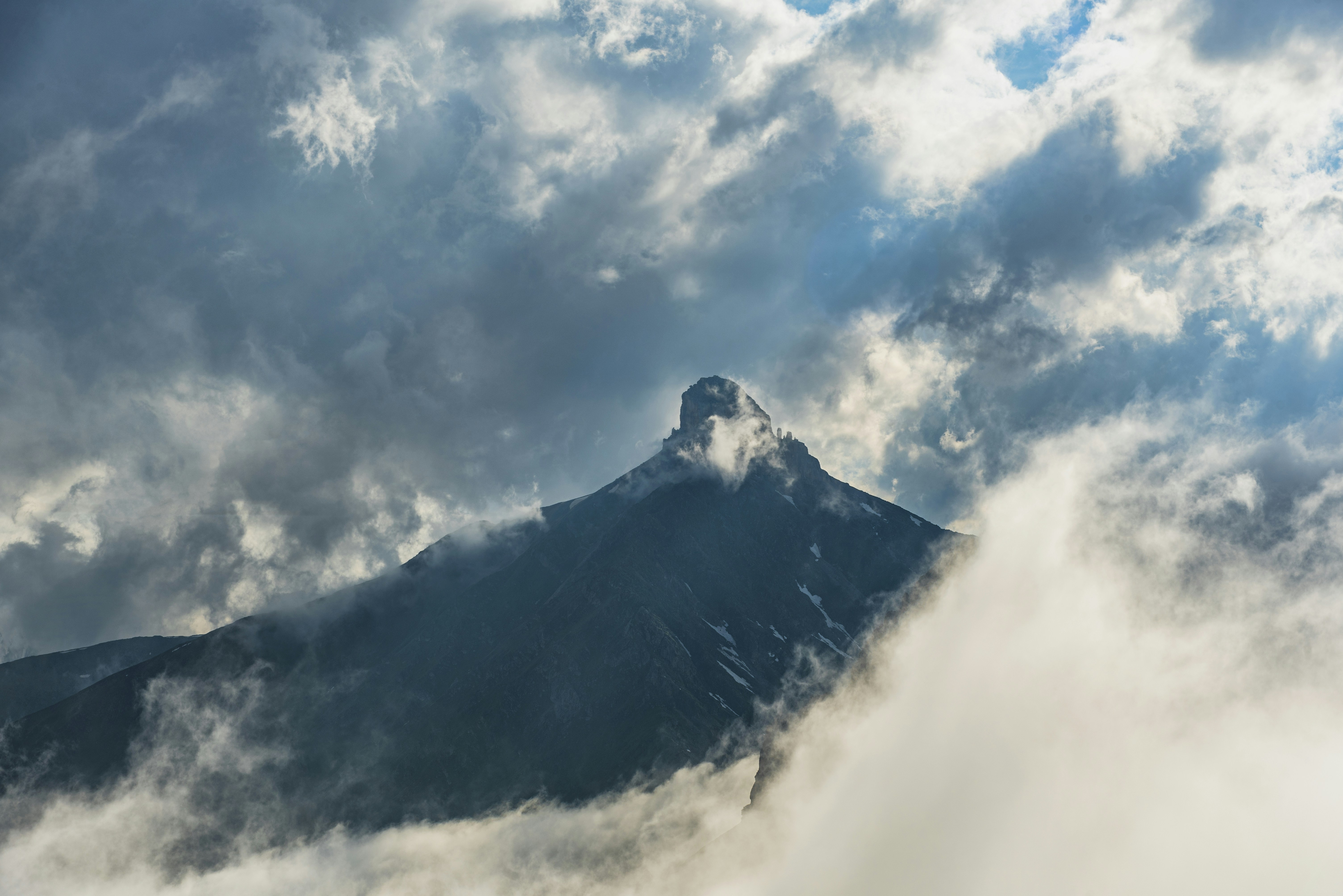 Peak Emergence Through Mist: A Lone Summit in the Clouds