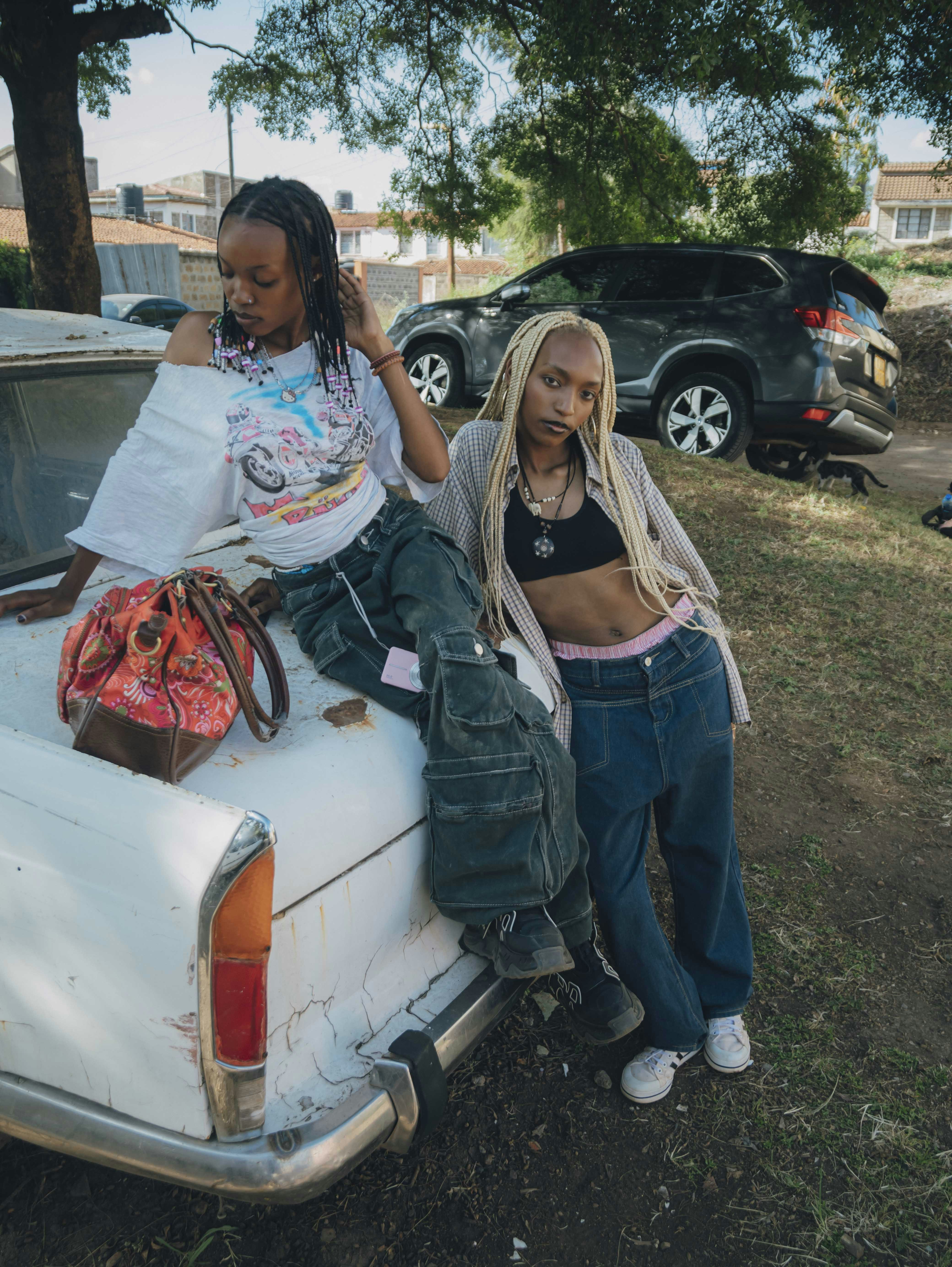 Two Friends on a Weathered Chevrolet: Casual Confidence in a Parklot Moment