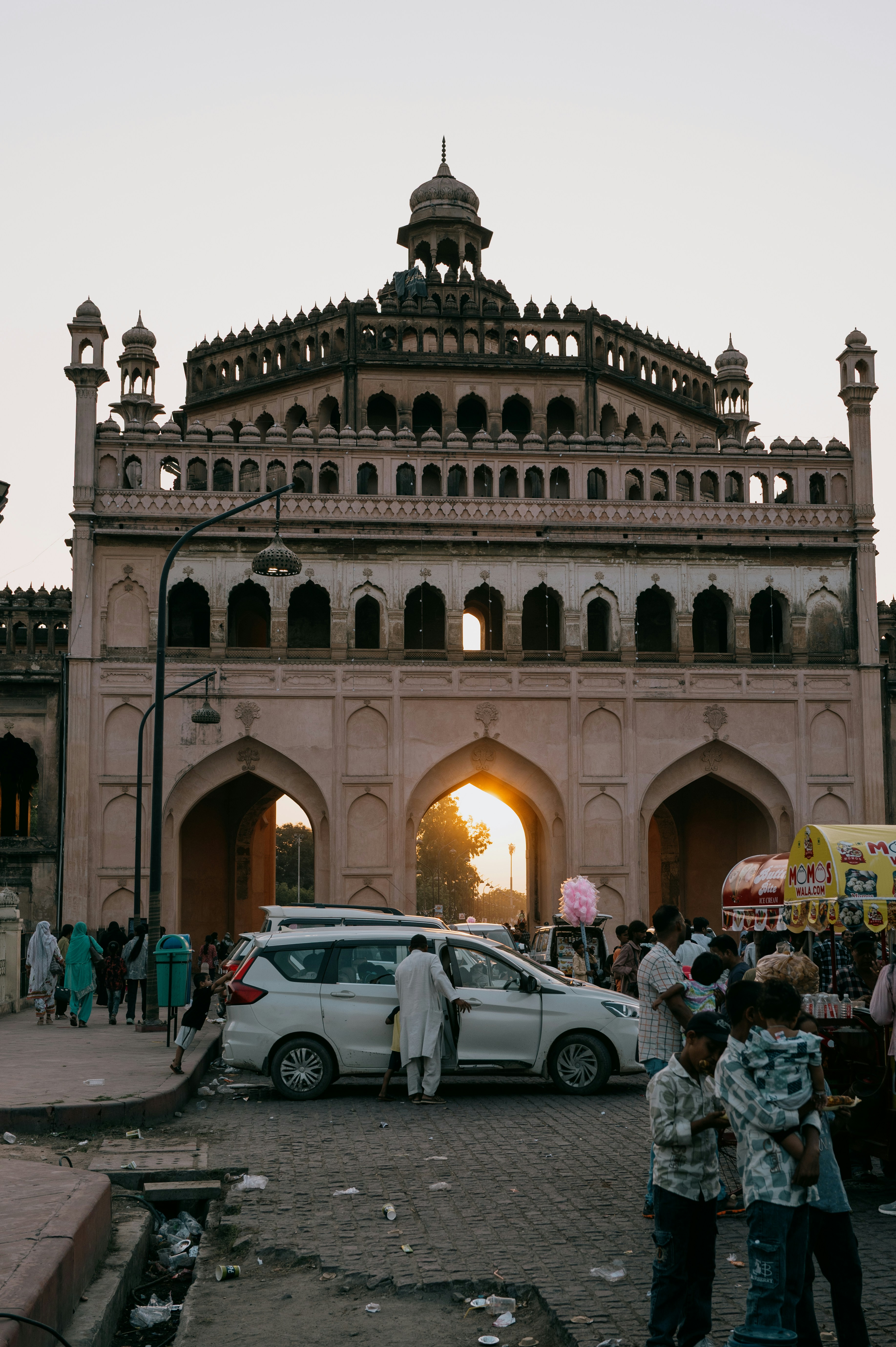 Gateway golden hour: archway framed with moving silhouettes beneath a domed façade