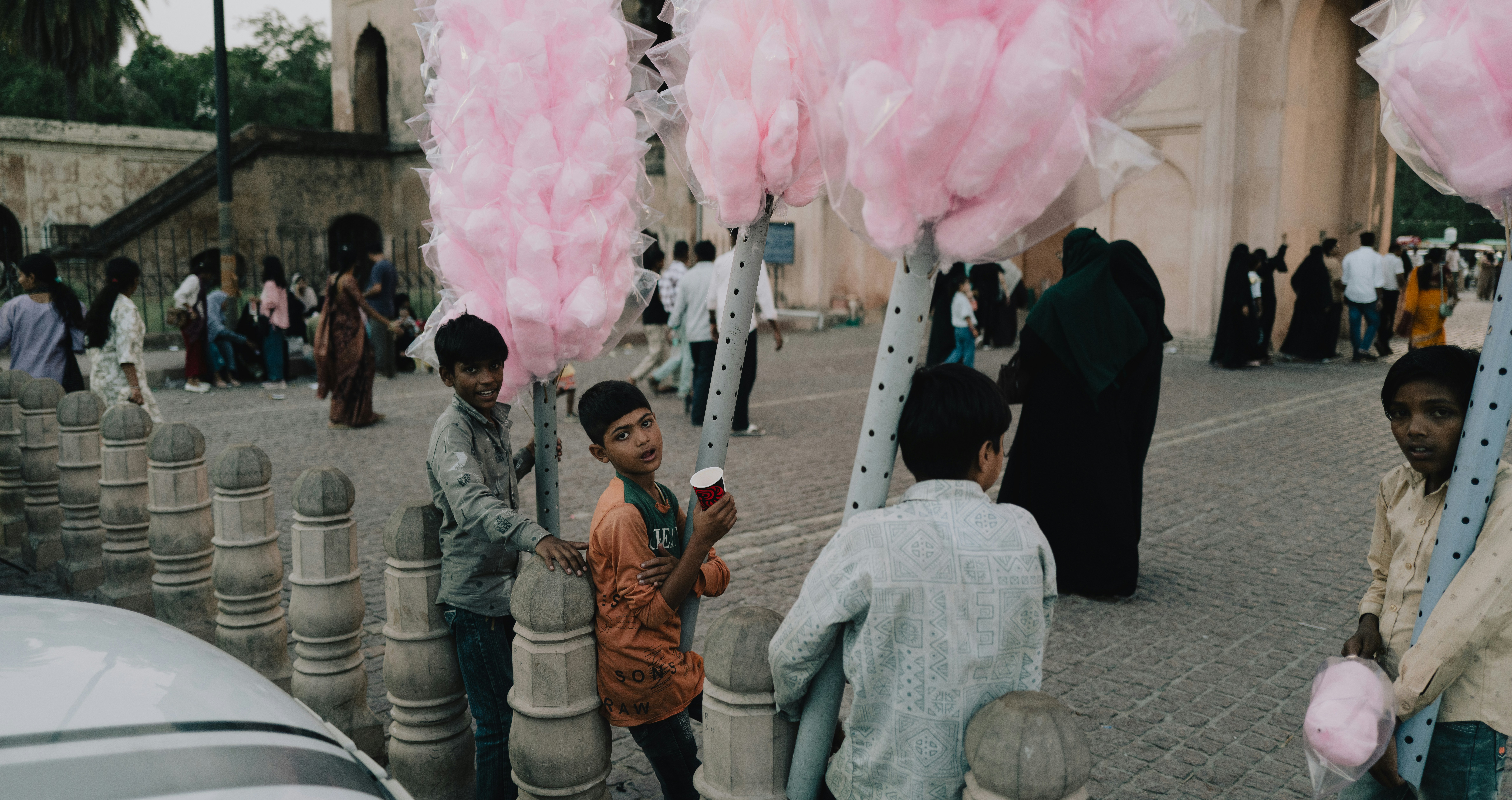 Midday Carnival: cotton candy clouds and curious kids at the city corridor