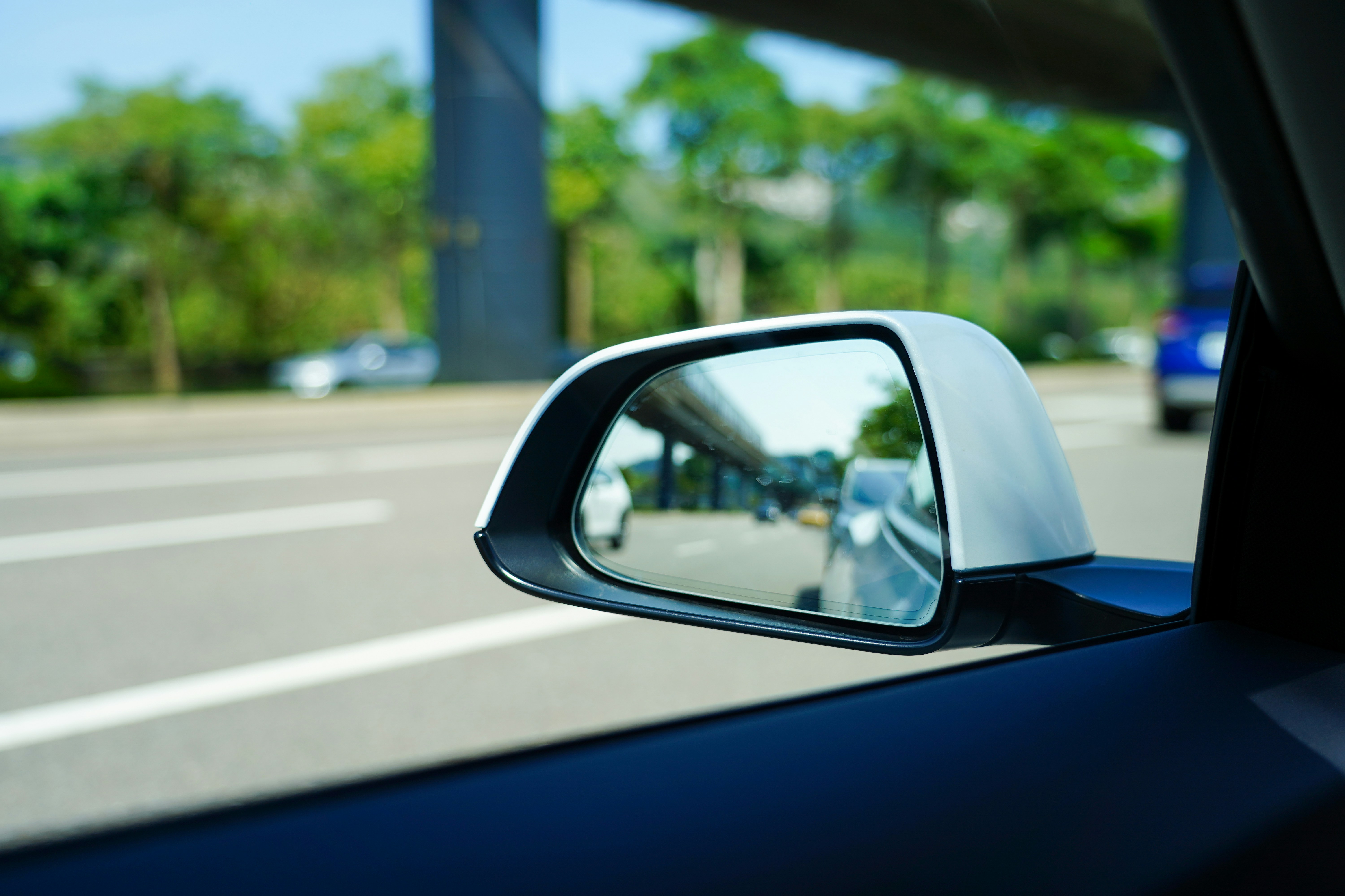 Side-View Mirror in Motion: Lane Lines and Reflective Road Ahead