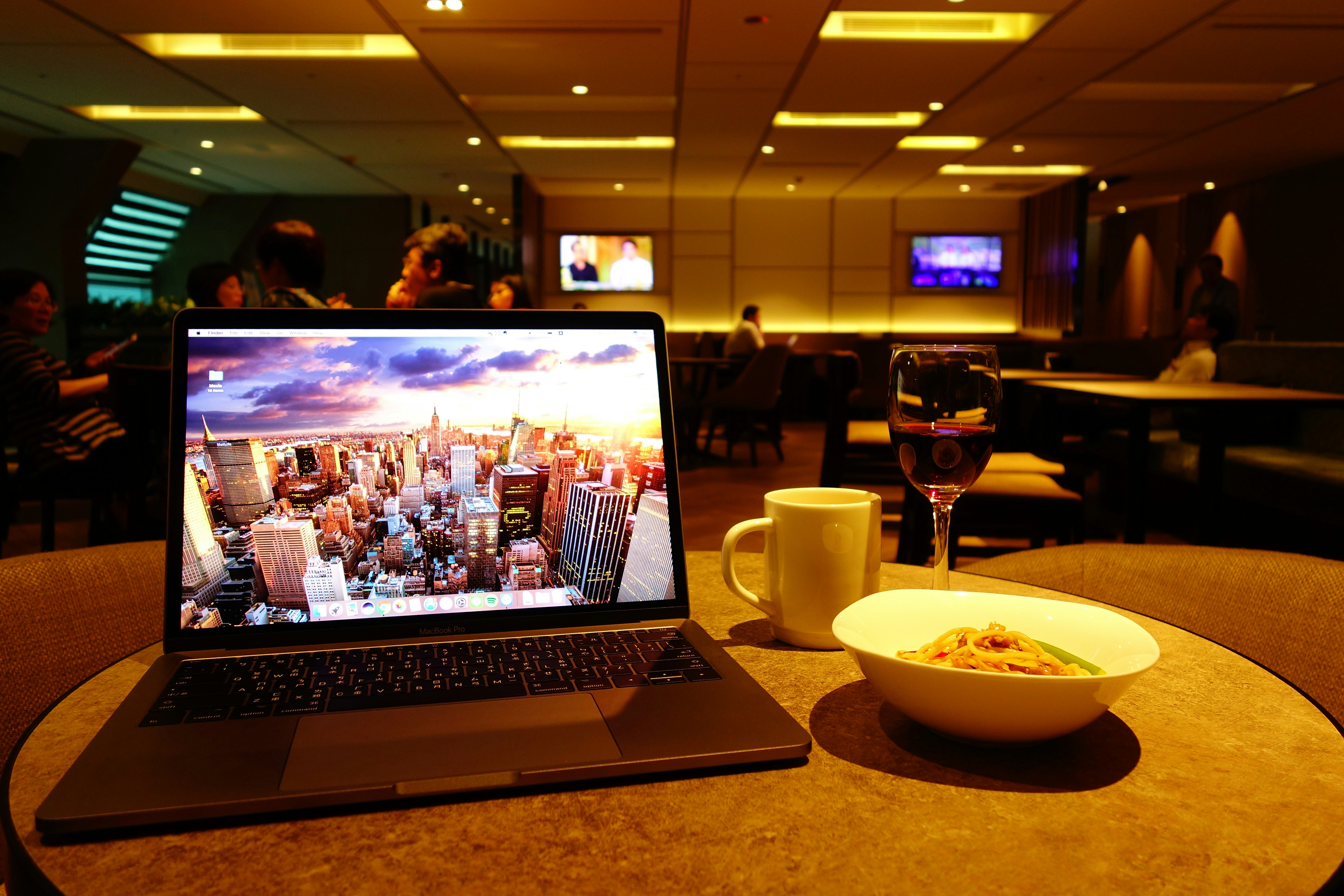 Urban laptop, pasta, and wine: a late-night hotel lounge desk scene