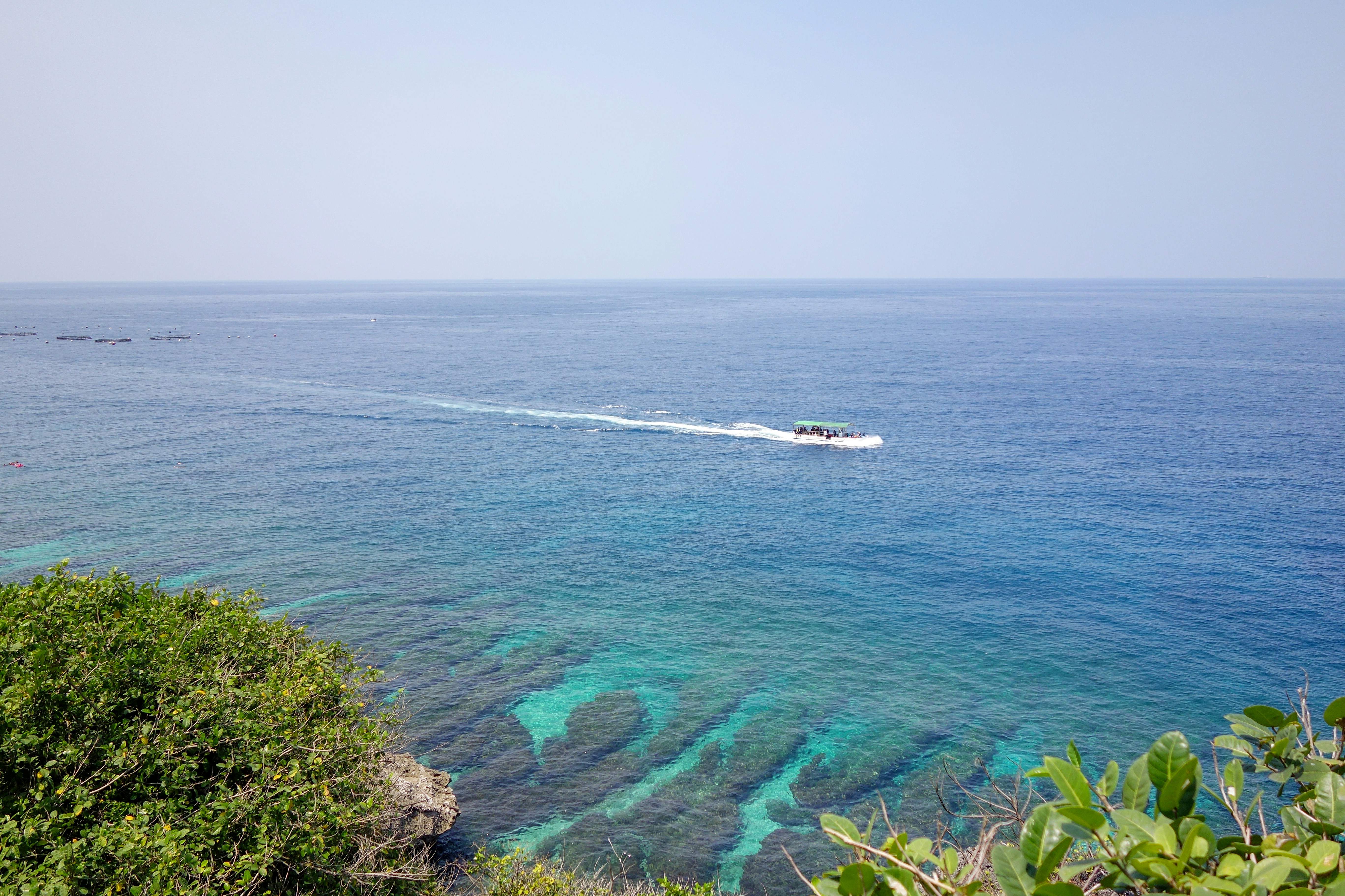 Azure Wake: A Motor Boat Carves the Sea Toward the Horizon