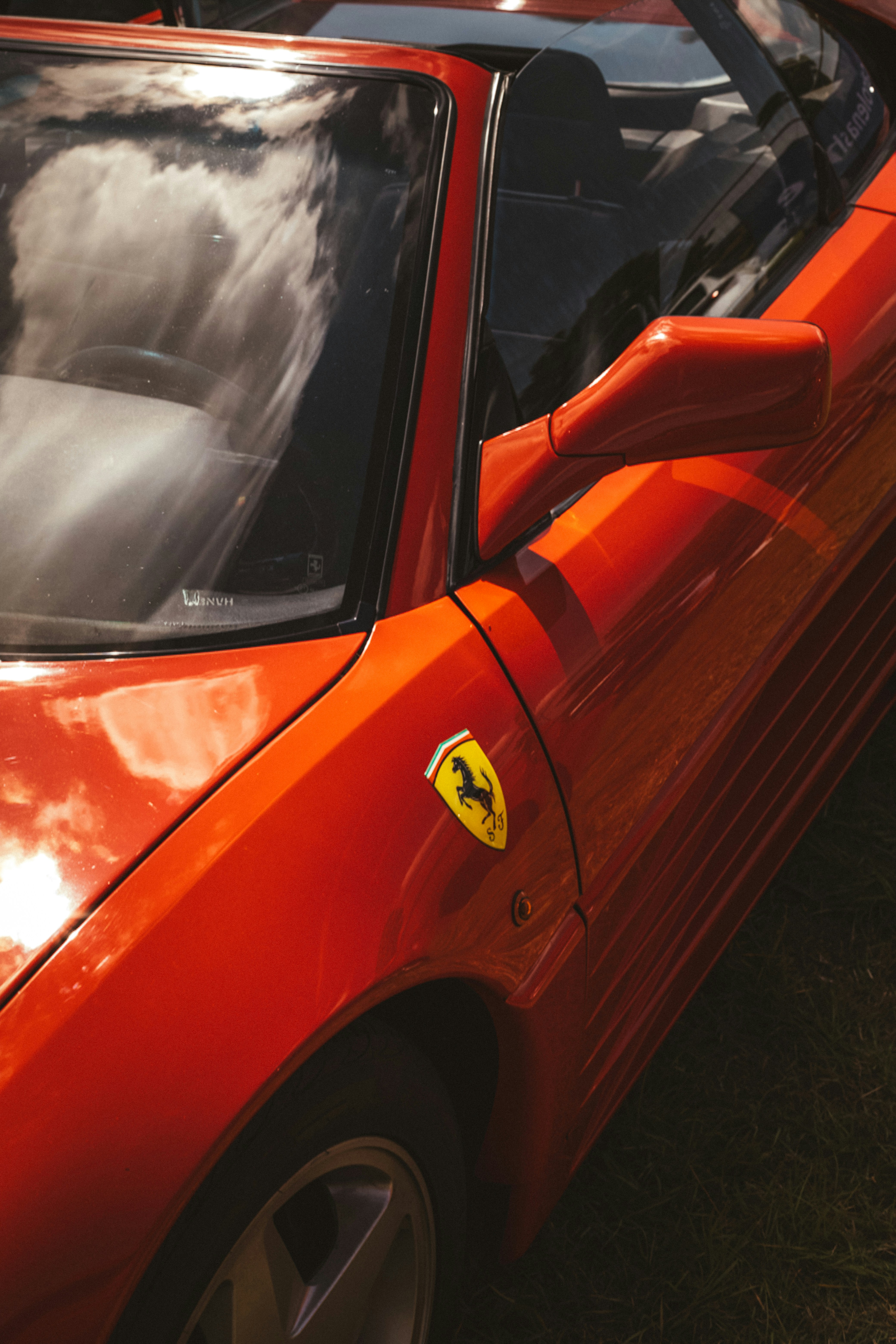 Fiery Red Ferrari Badge under Sunlit Curves