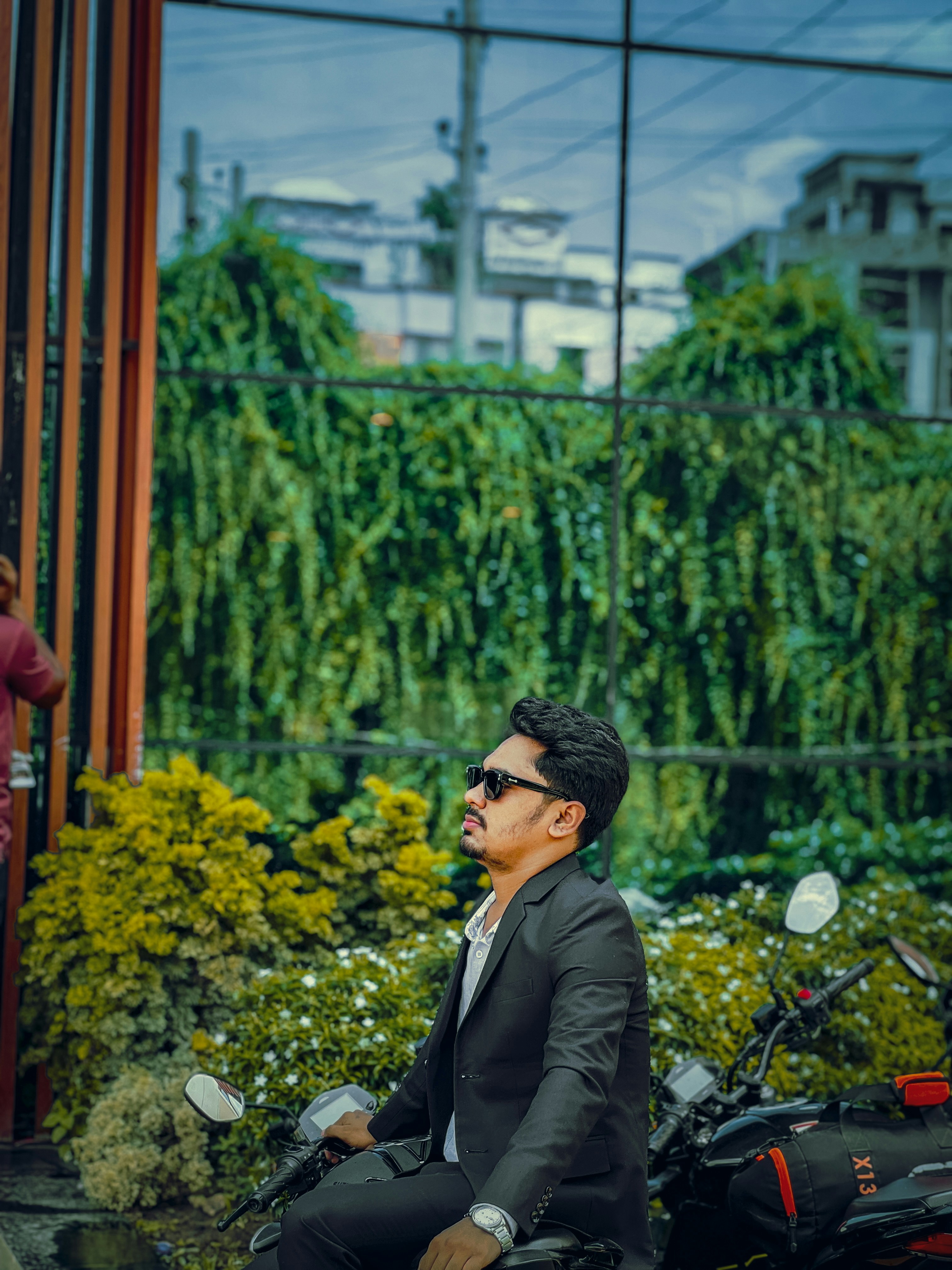 Urban chic: a suited rider pauses by a glass wall garden