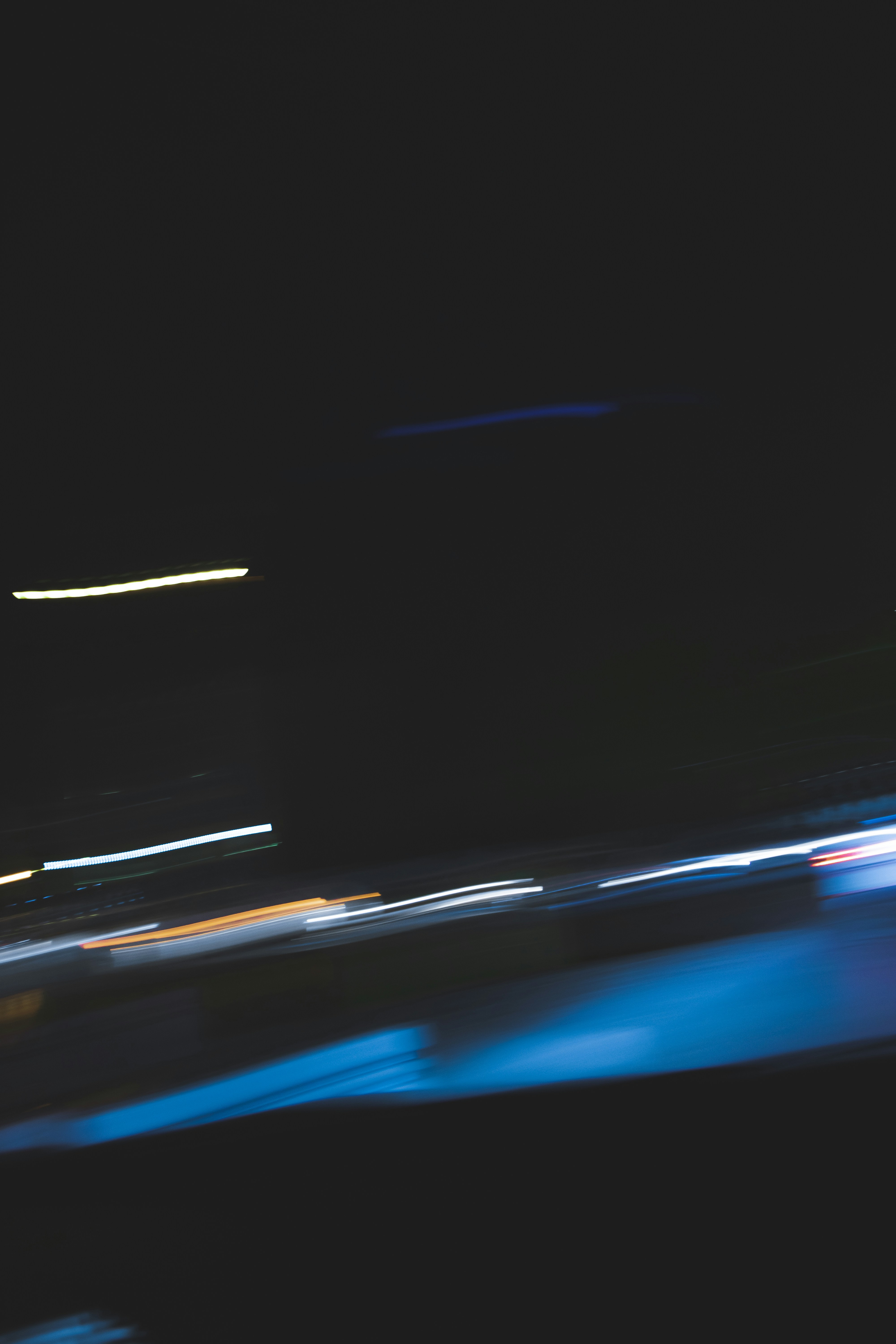 Lengthwise Night Run: Neon Streaks Across a Turbulent Street