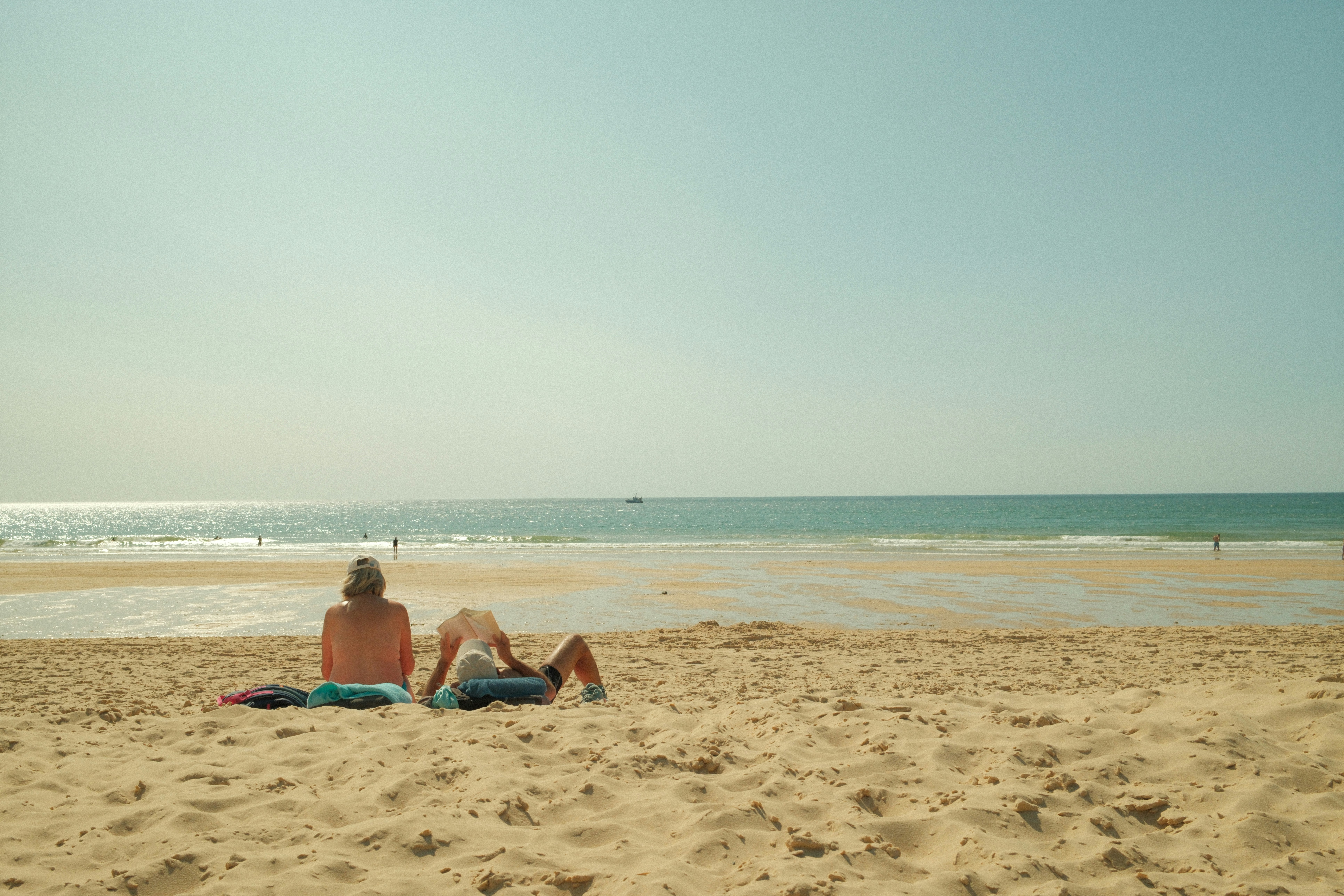 Sunlit Couple on a Quiet Beach at Dusk