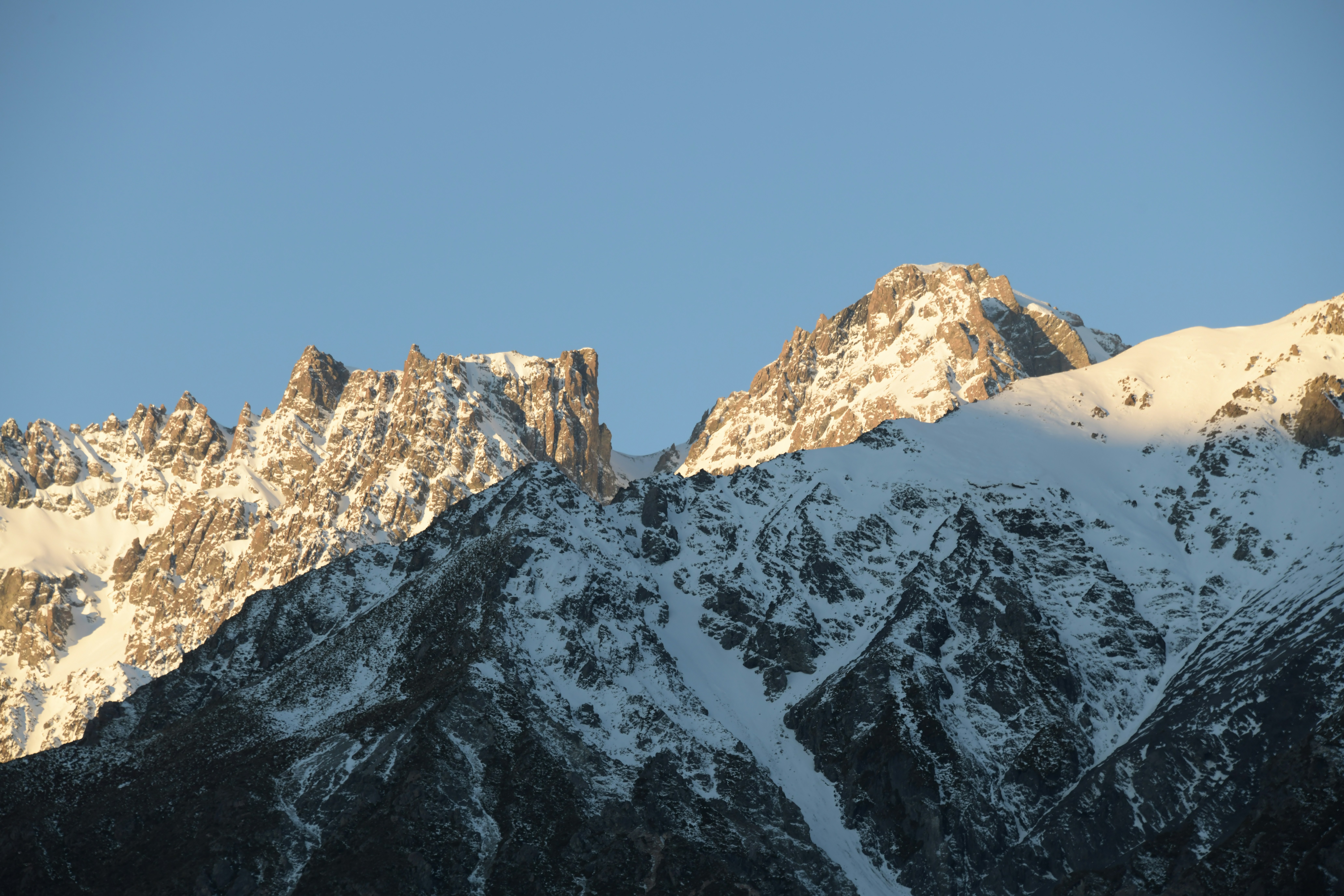 Golden Crown: Sunlit Peaks Against a Clear Blue Sky