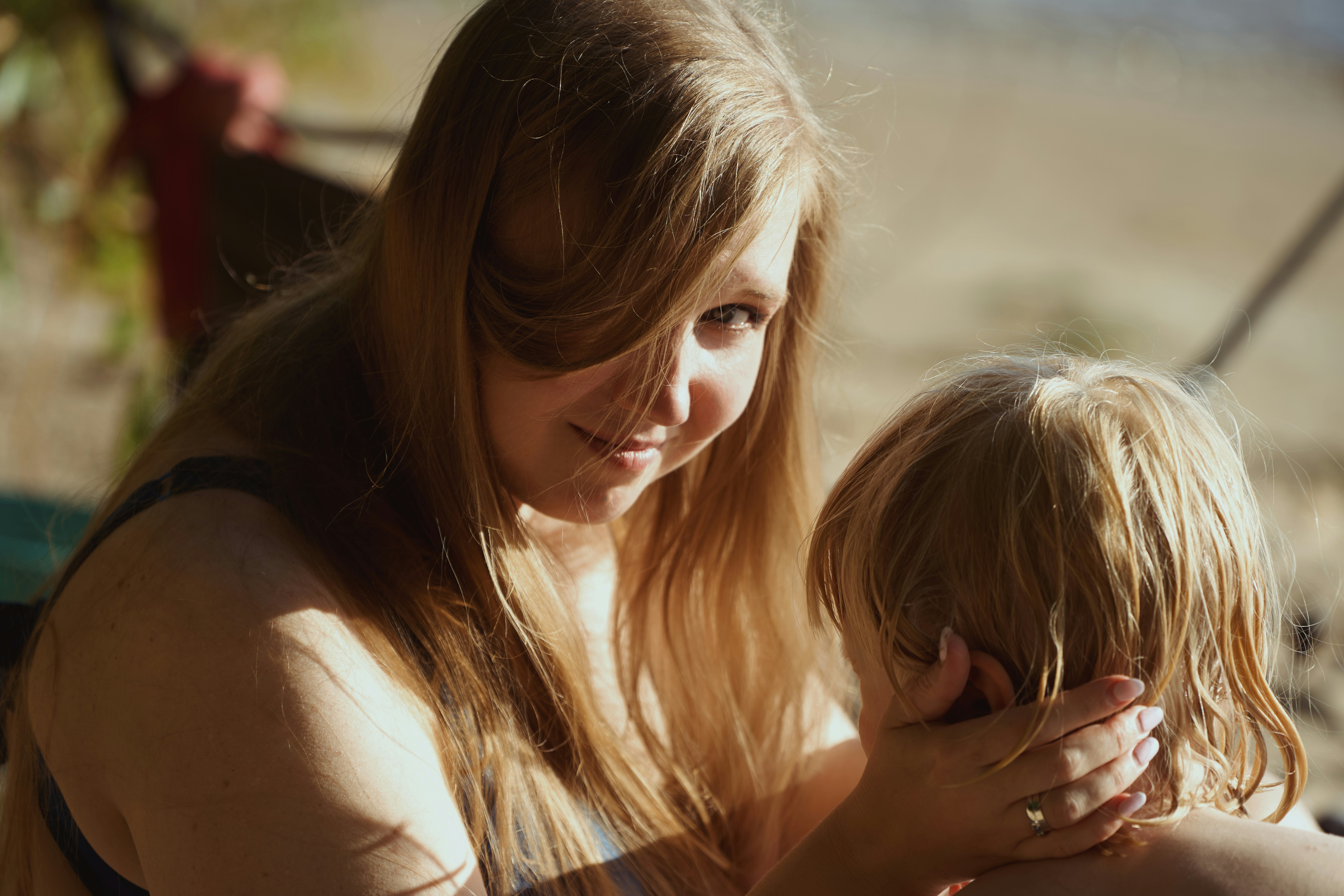 Tender Moment: A Mother Comforts Her Child Under Soft Afternoon Light