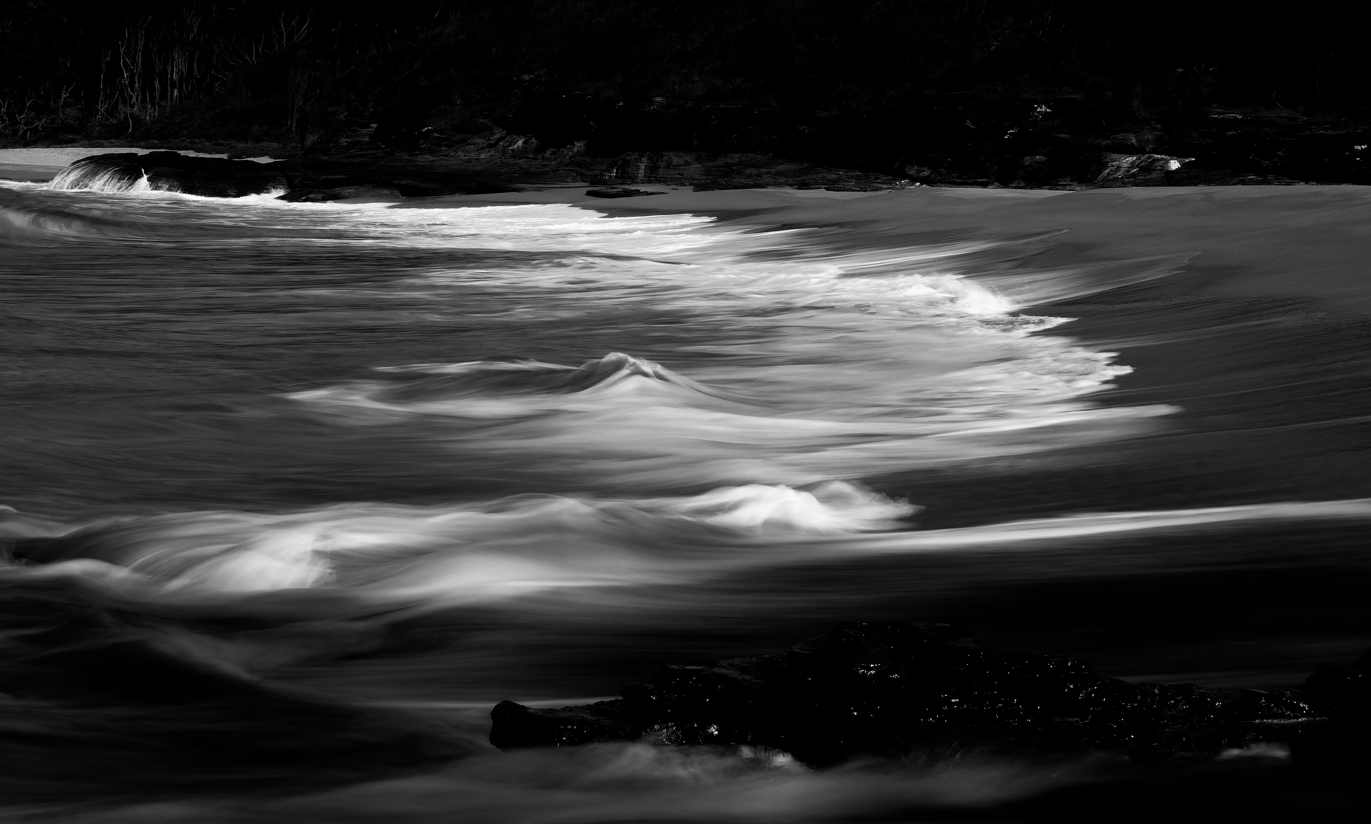 Moonlit Tide: A Silhouette of Waves and Shoreline in Motion