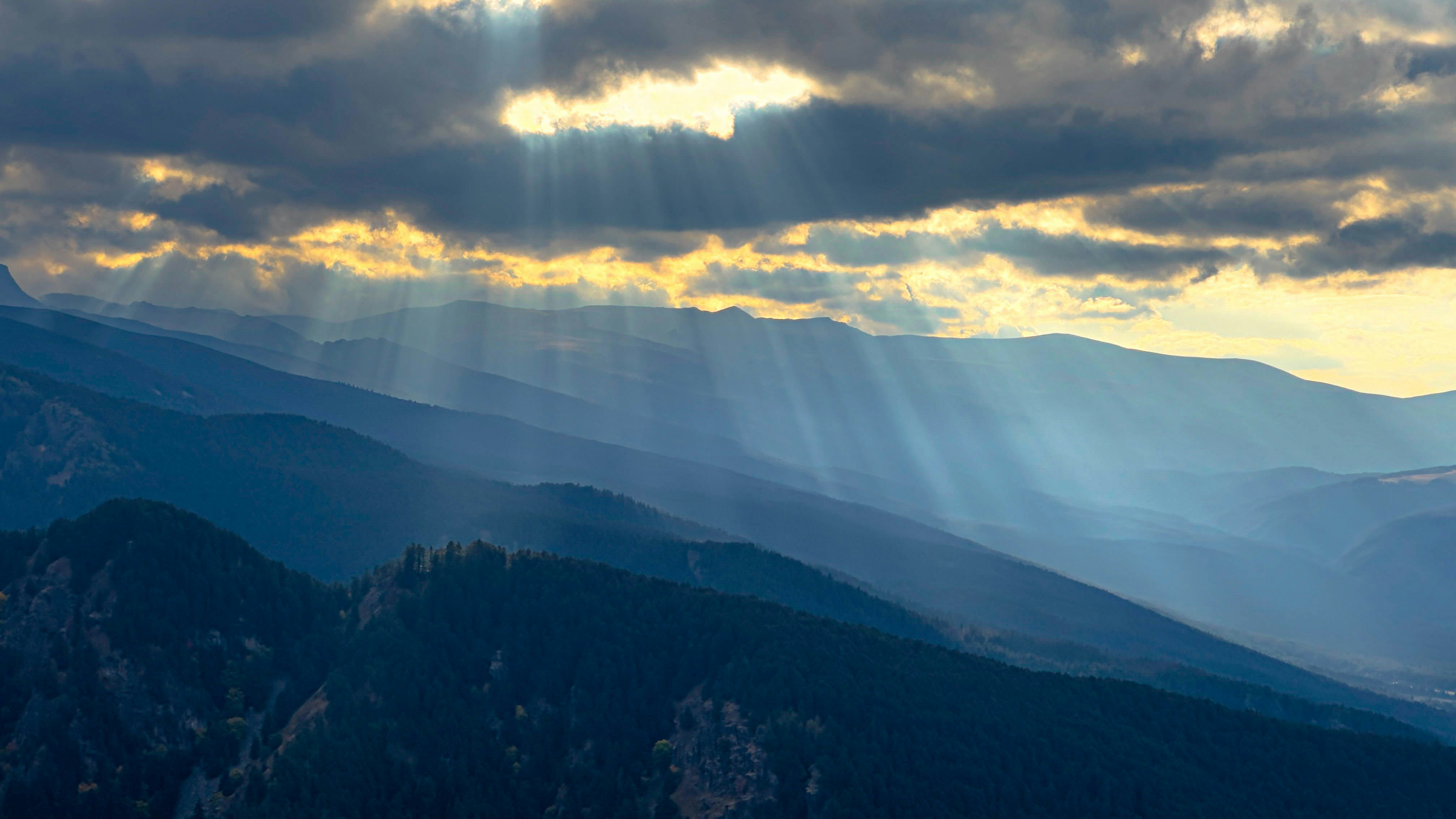 Rays Through the Rift: Mountain Ranges Whisper under a Sidelit Sky