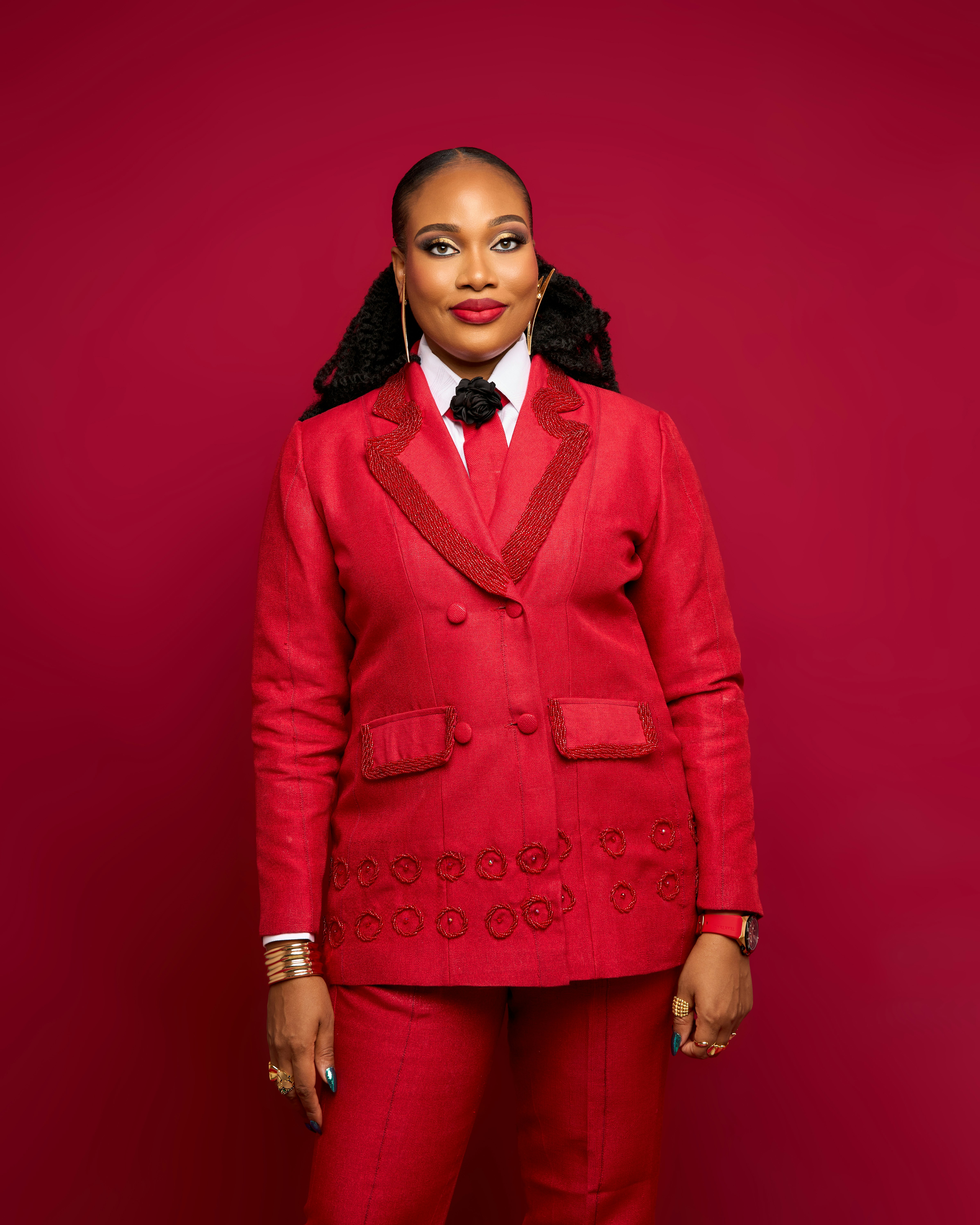Crimson Suit, Confident Pose: A Formal Portrait Against a Velvet Red Backdrop