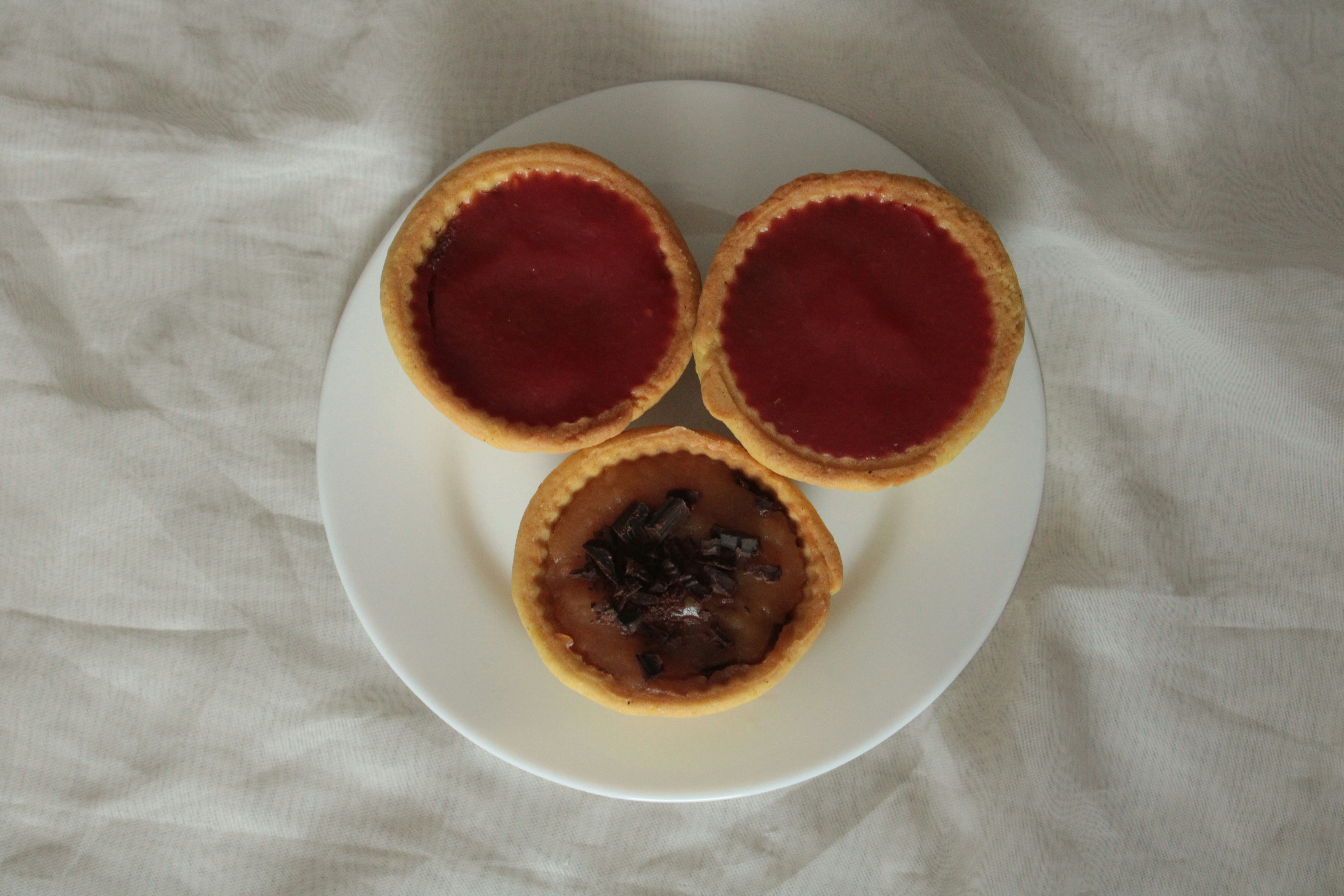 Triad of Tartlets: A Gentle Still Life on a Soft Linen Stage