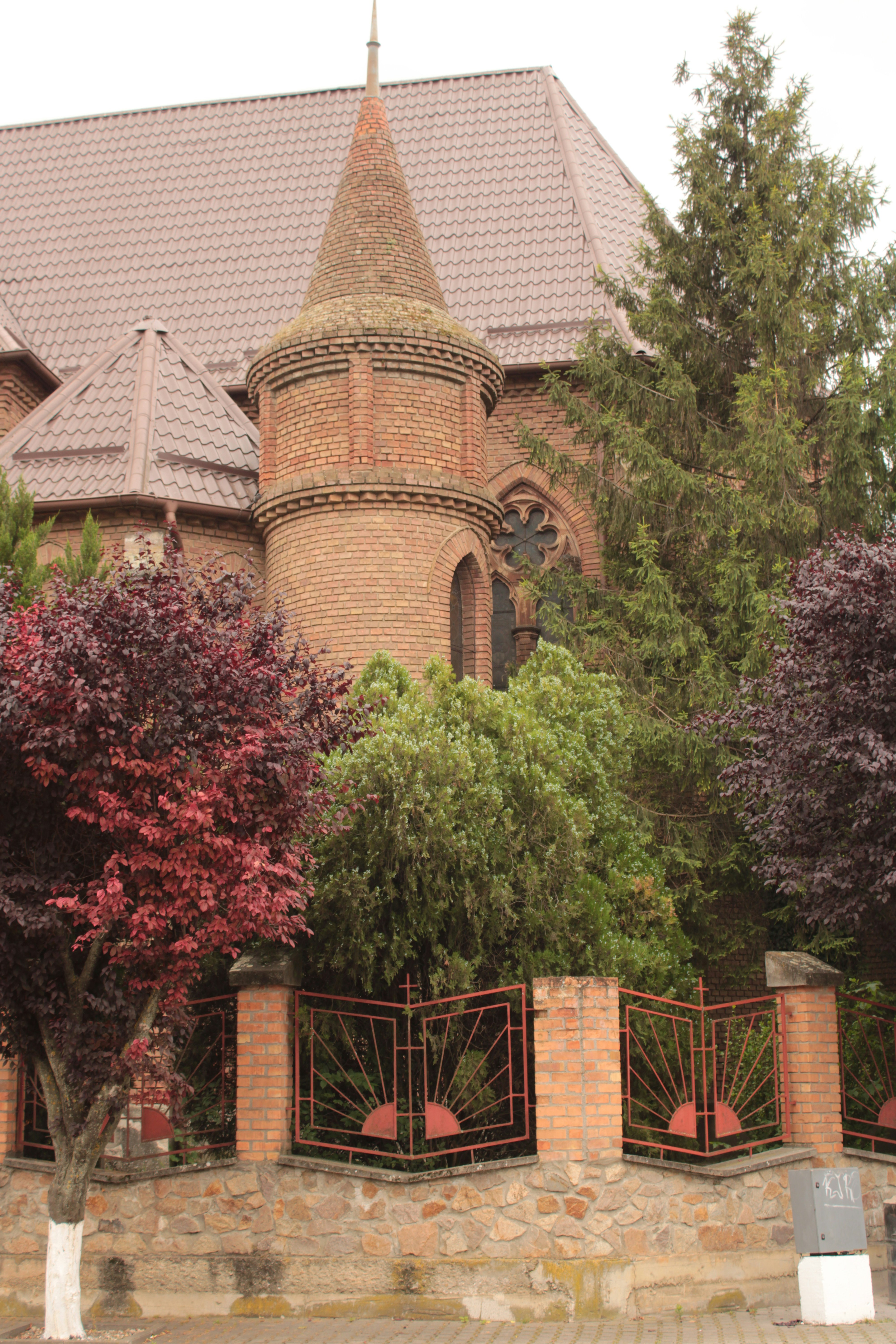 Castle turret and iron gate framed by autumn trees