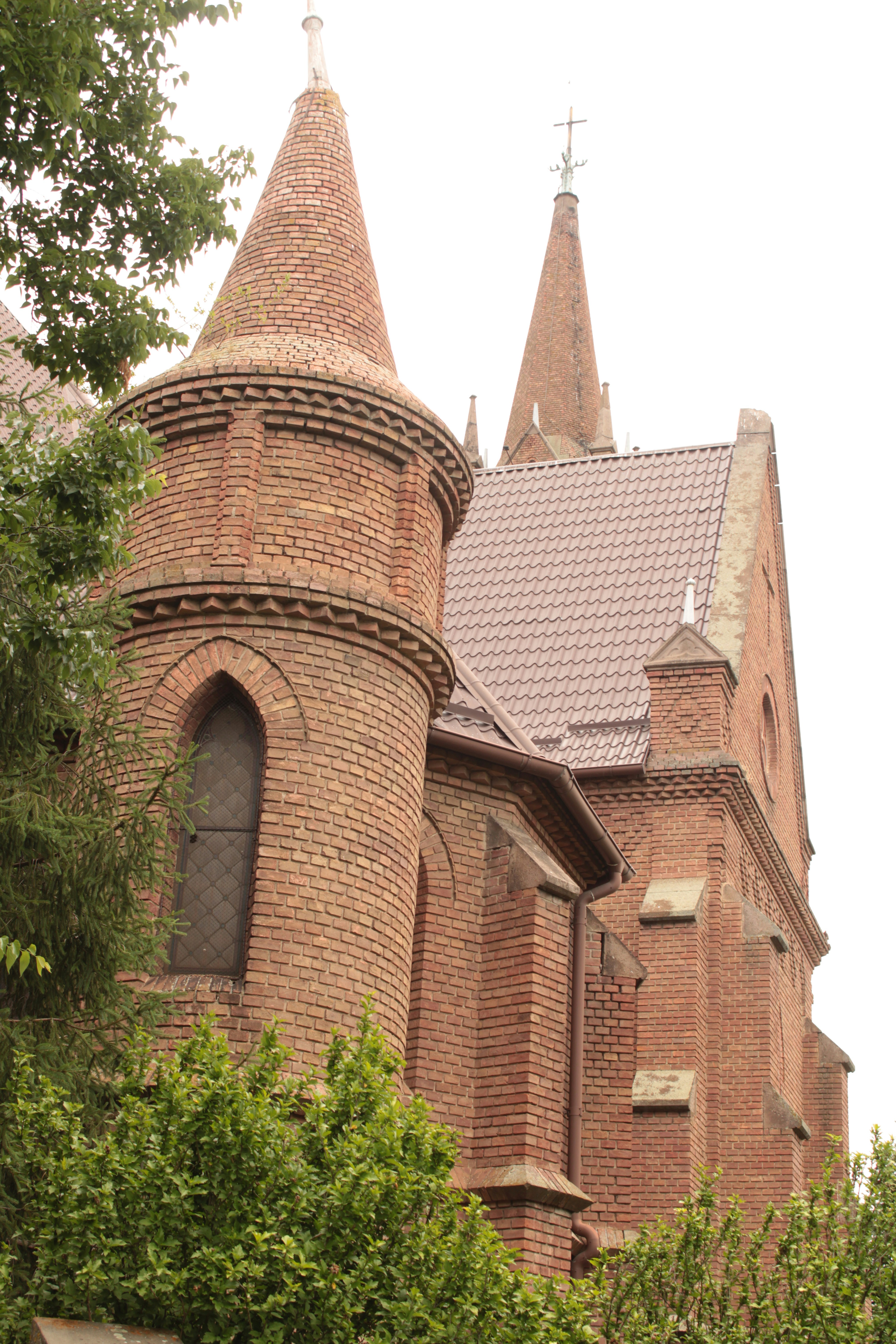 Brick spires and ivy-clad arcades rising beside a church