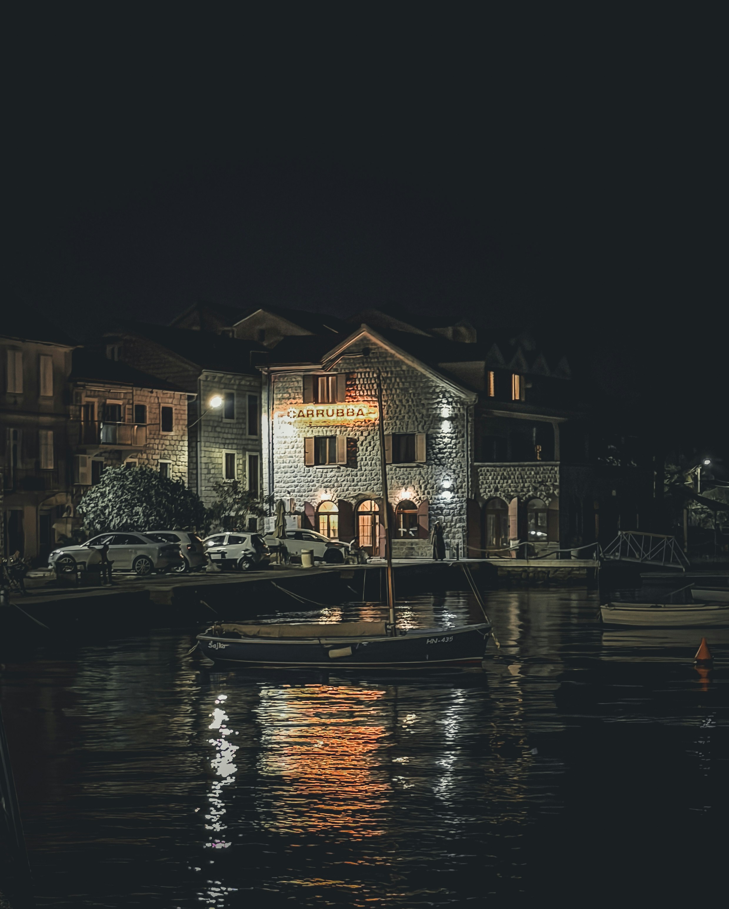 Harbor Lights: Stone Inn Quietly Glows Over Calm Waters