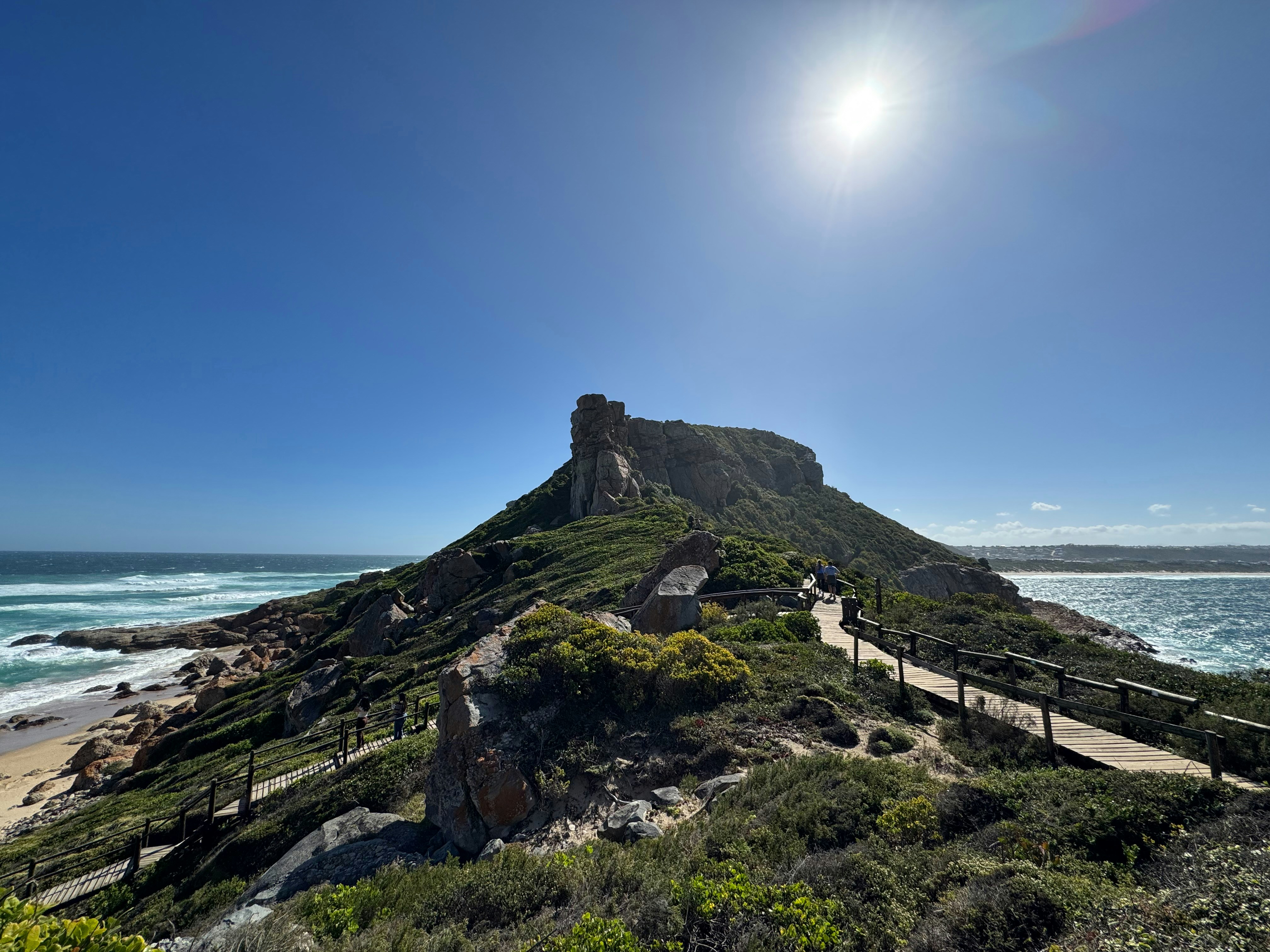 Rocky promontory crowned by a cliff fortress under a bright midday sky