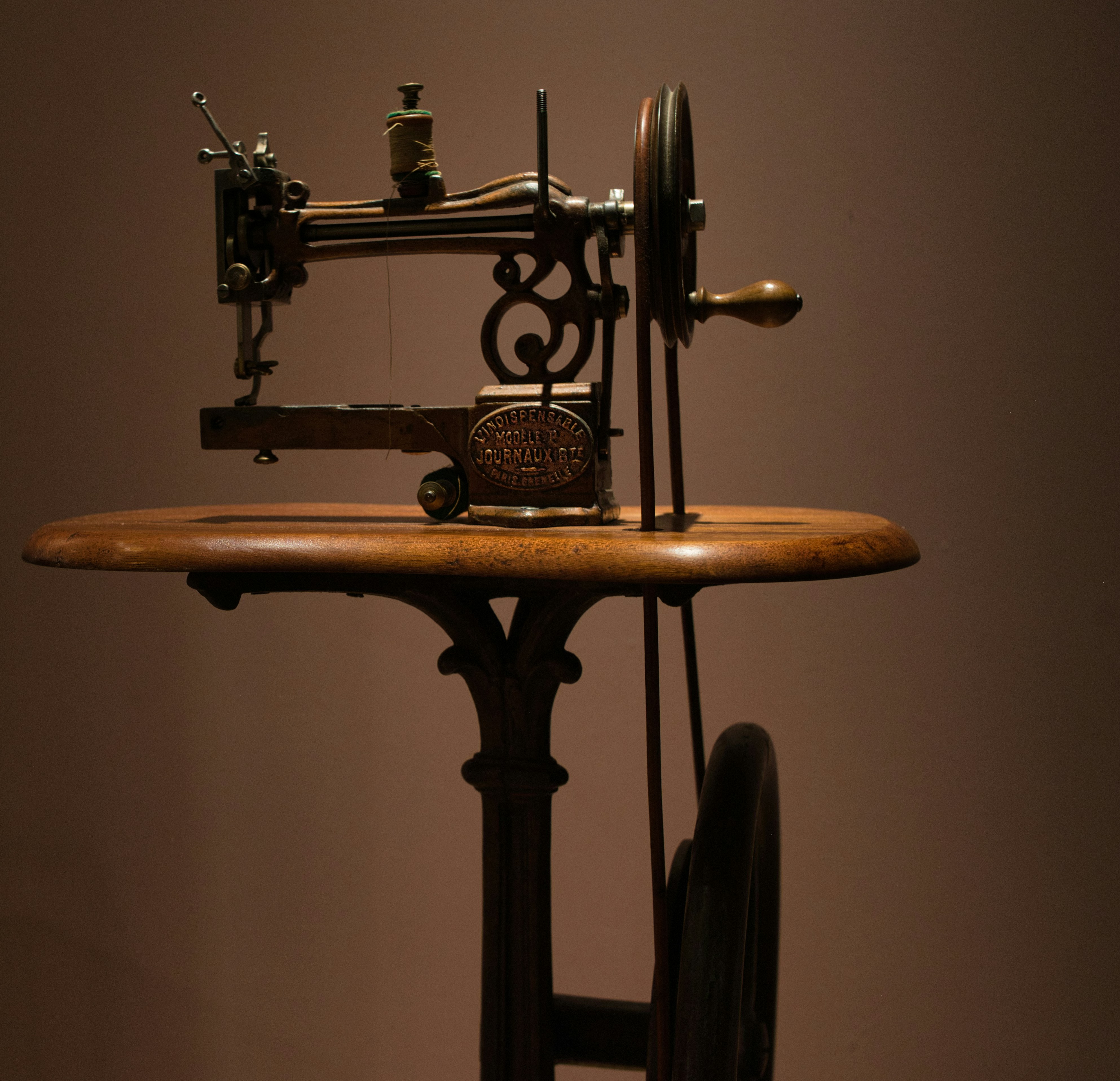 Threaded Time: an antique sewing machine on a carved wooden table under warm light