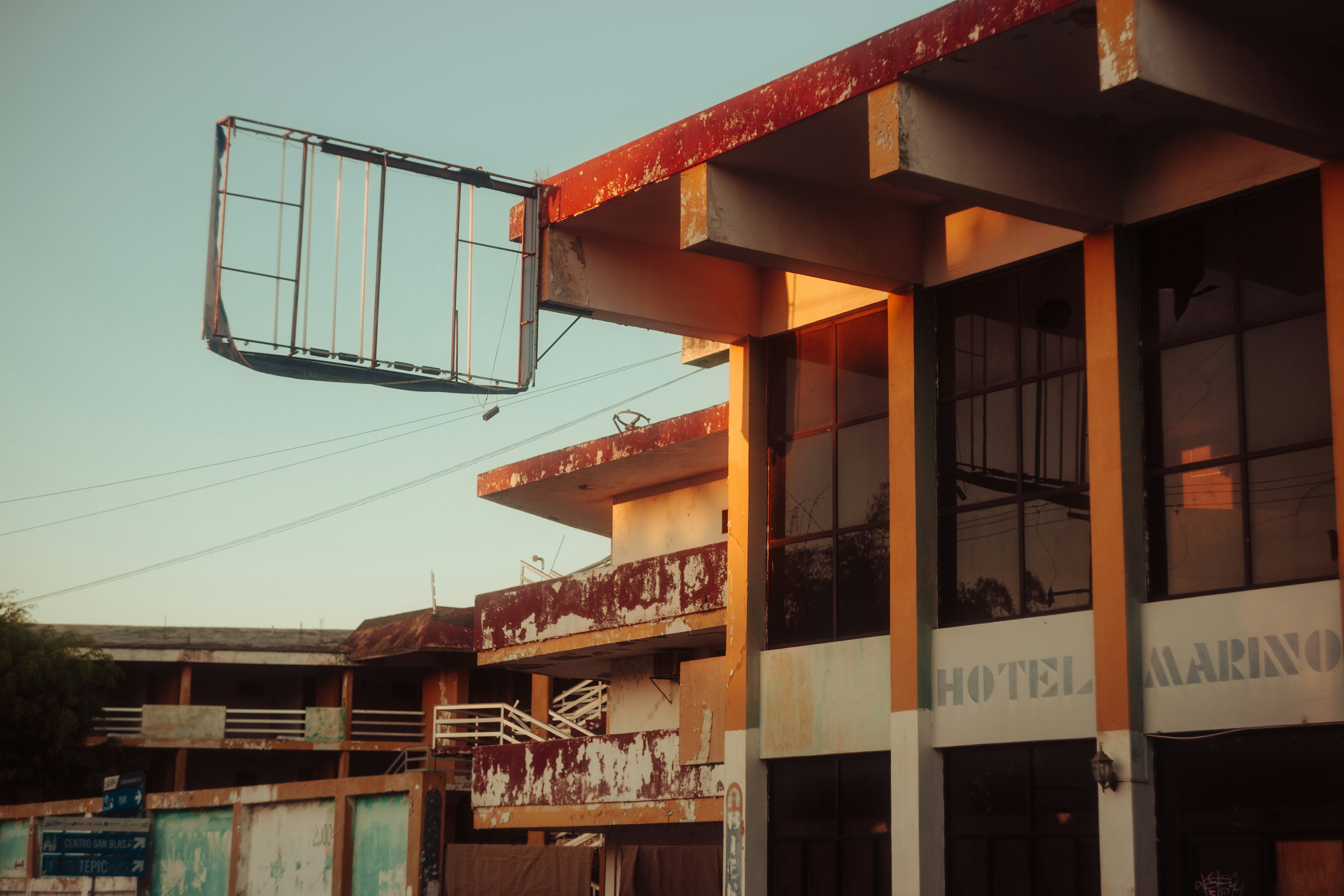 Abandoned hotel façade under warm late-afternoon glow with a protruding balcony frame