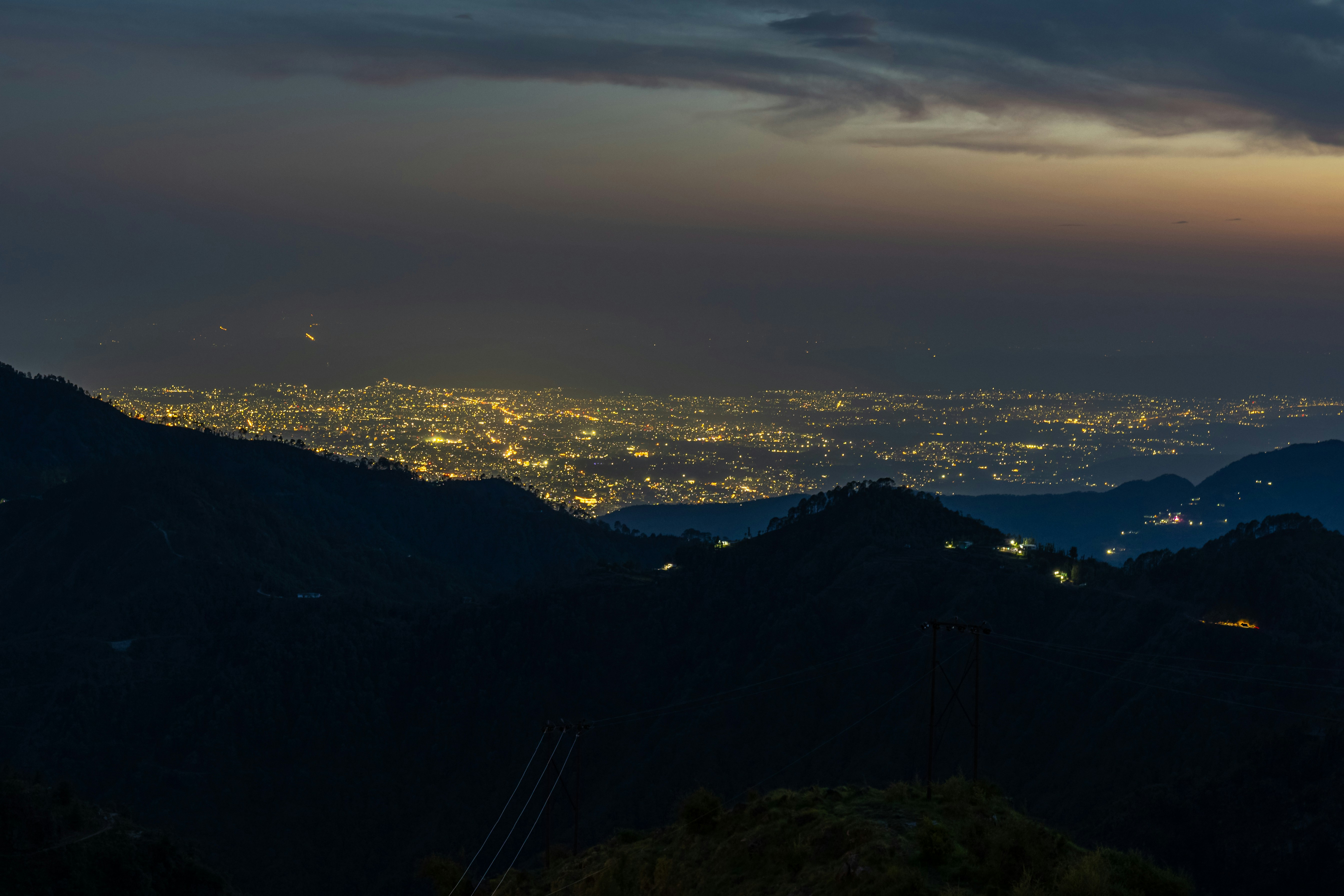 Distant City Lights from a Quiet Mountain Pass at Dusk