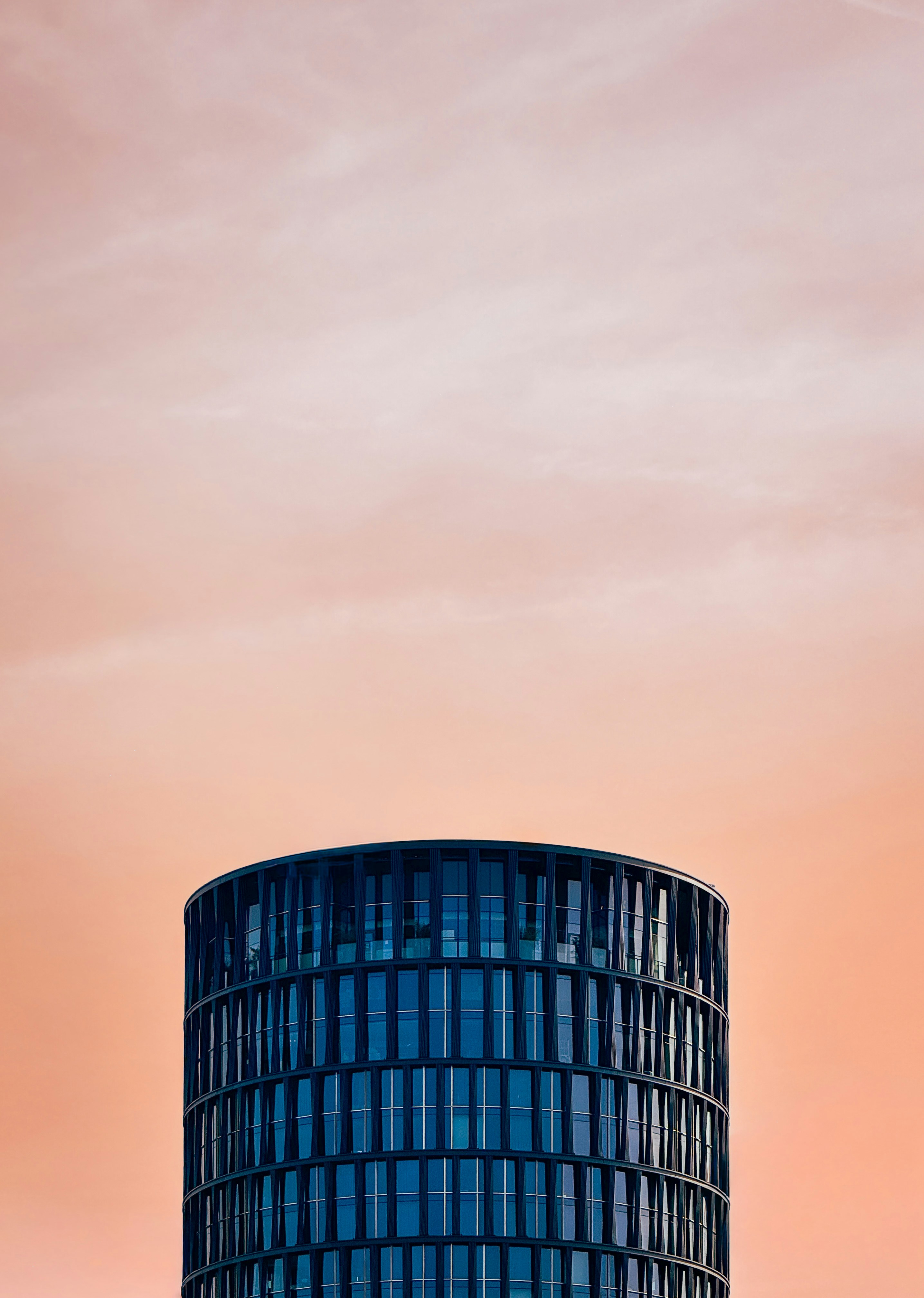Crescent Glass Tower Against a Peach Sky