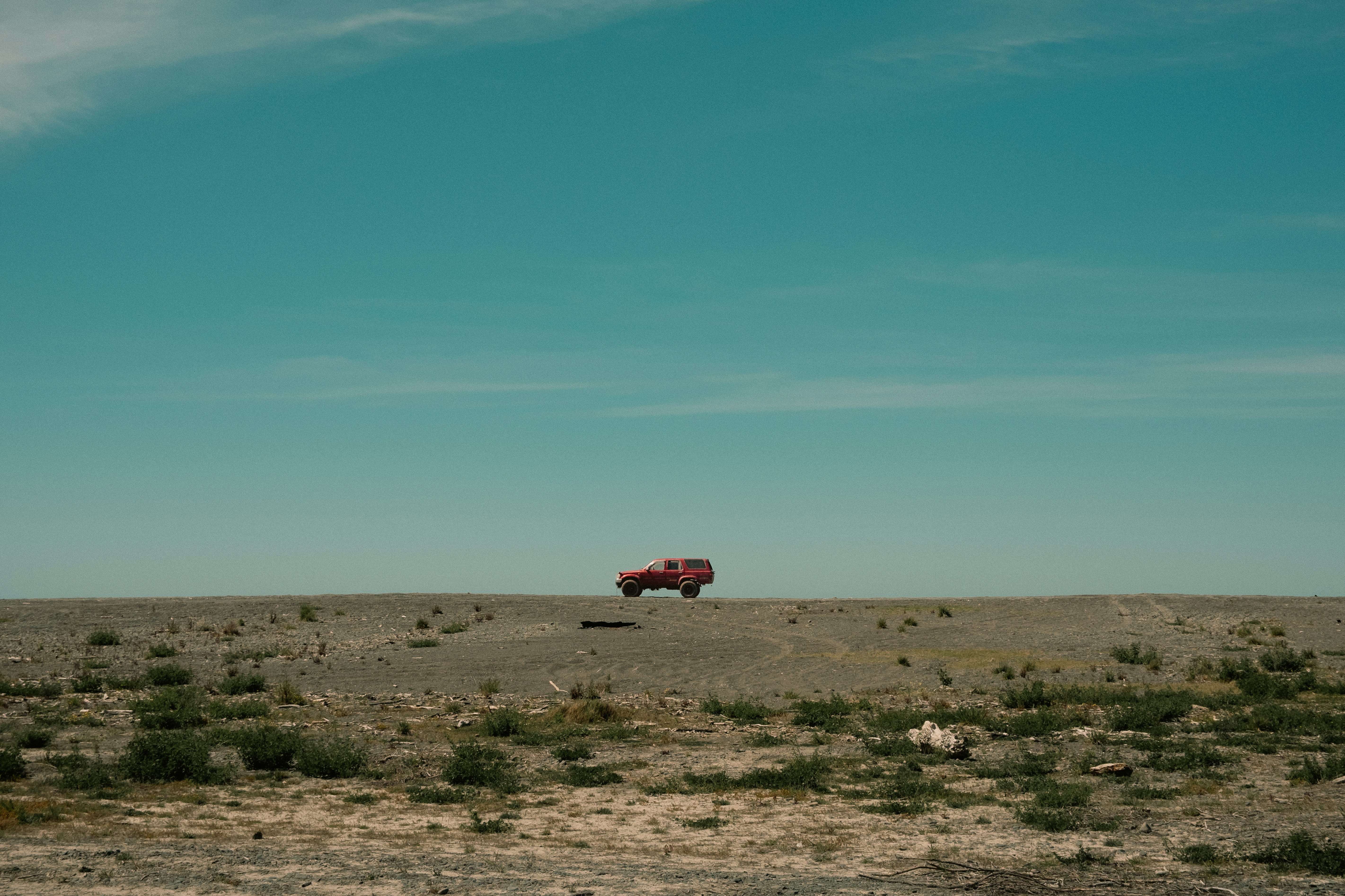 Red Vehicle on the Distant Rim