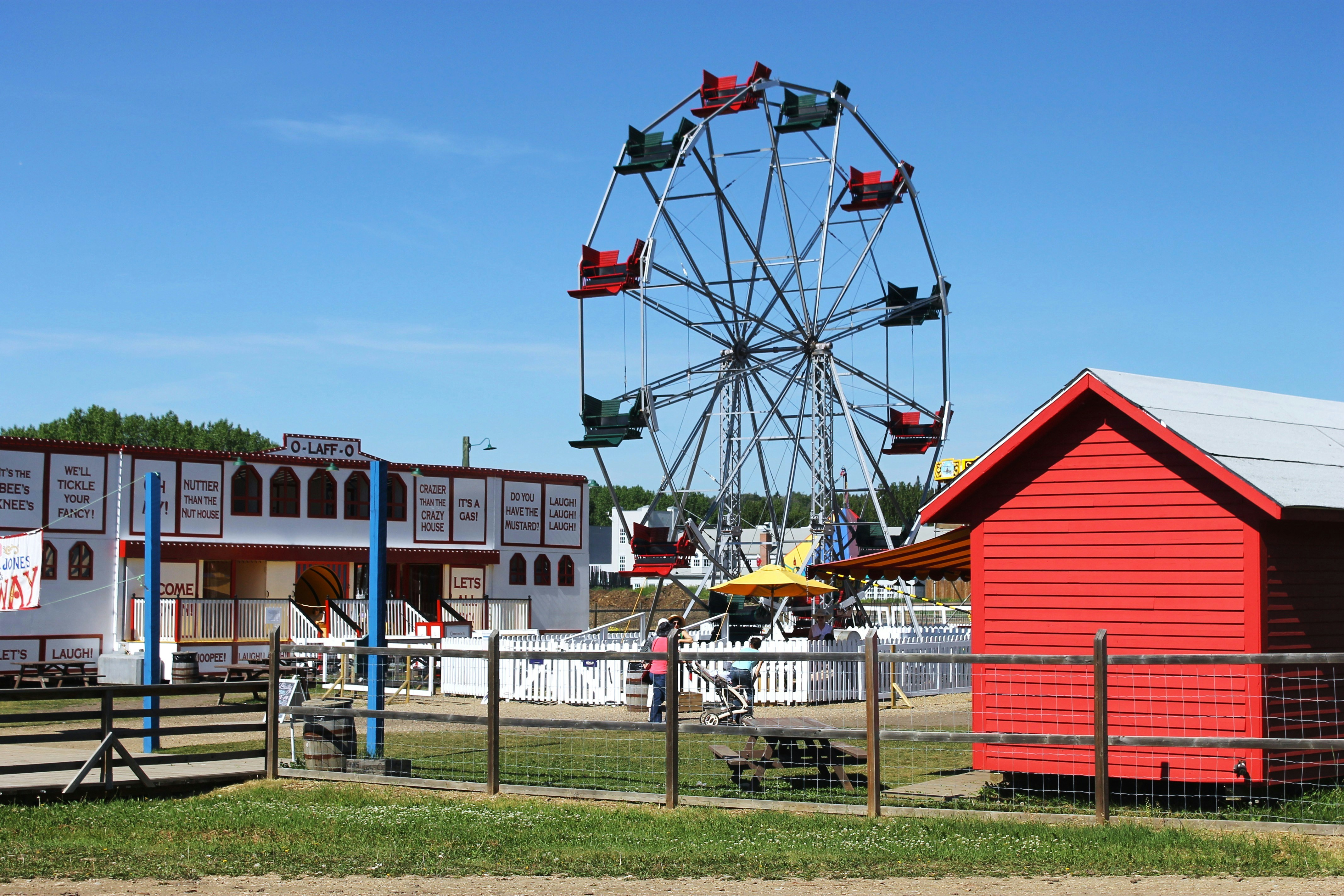 Ferris Wheel Framed by a Red Quonset and a Sunny Fairground