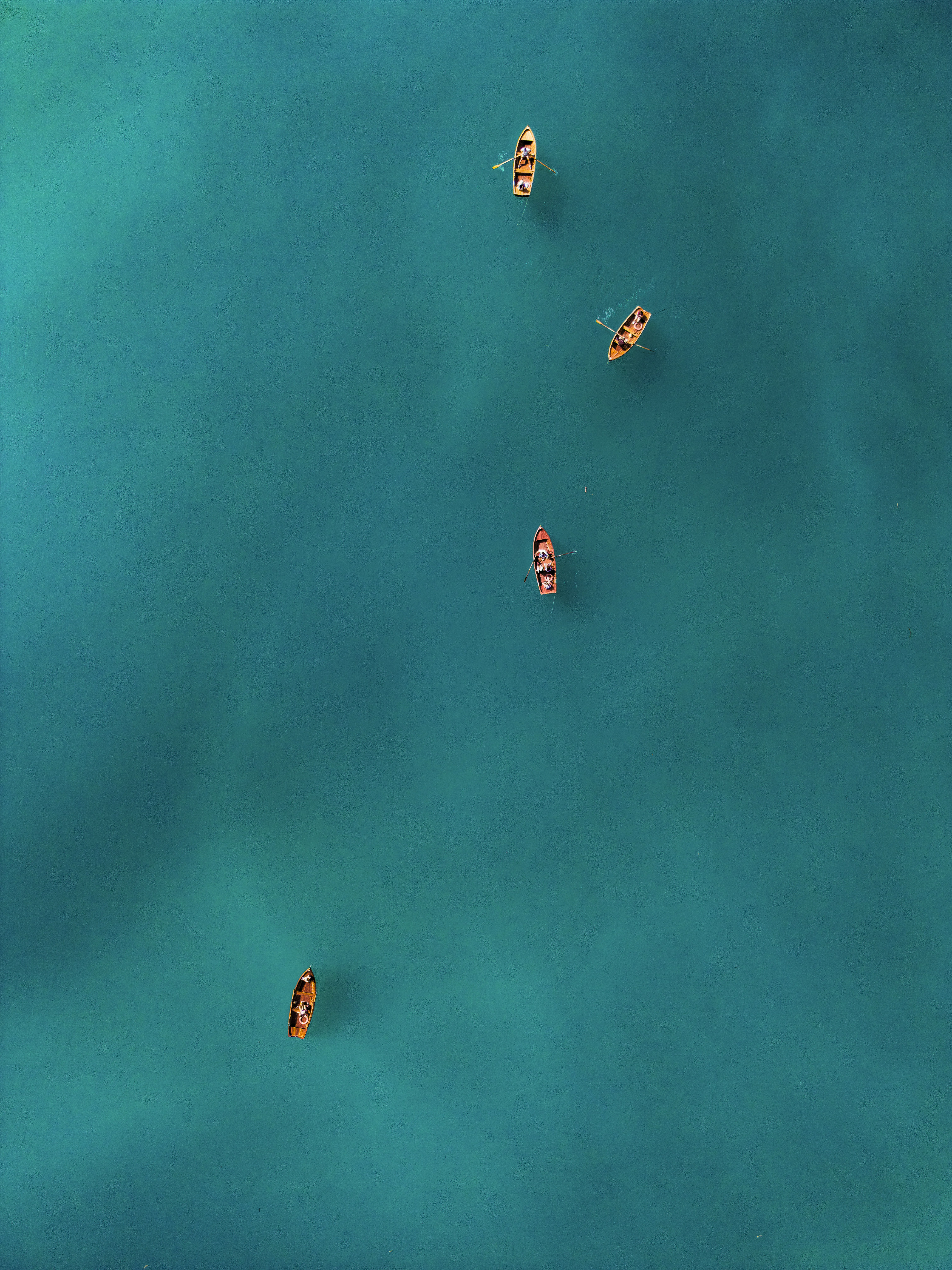 Azure Drift: Five Rowboats Nestled in Calm Teal Waters