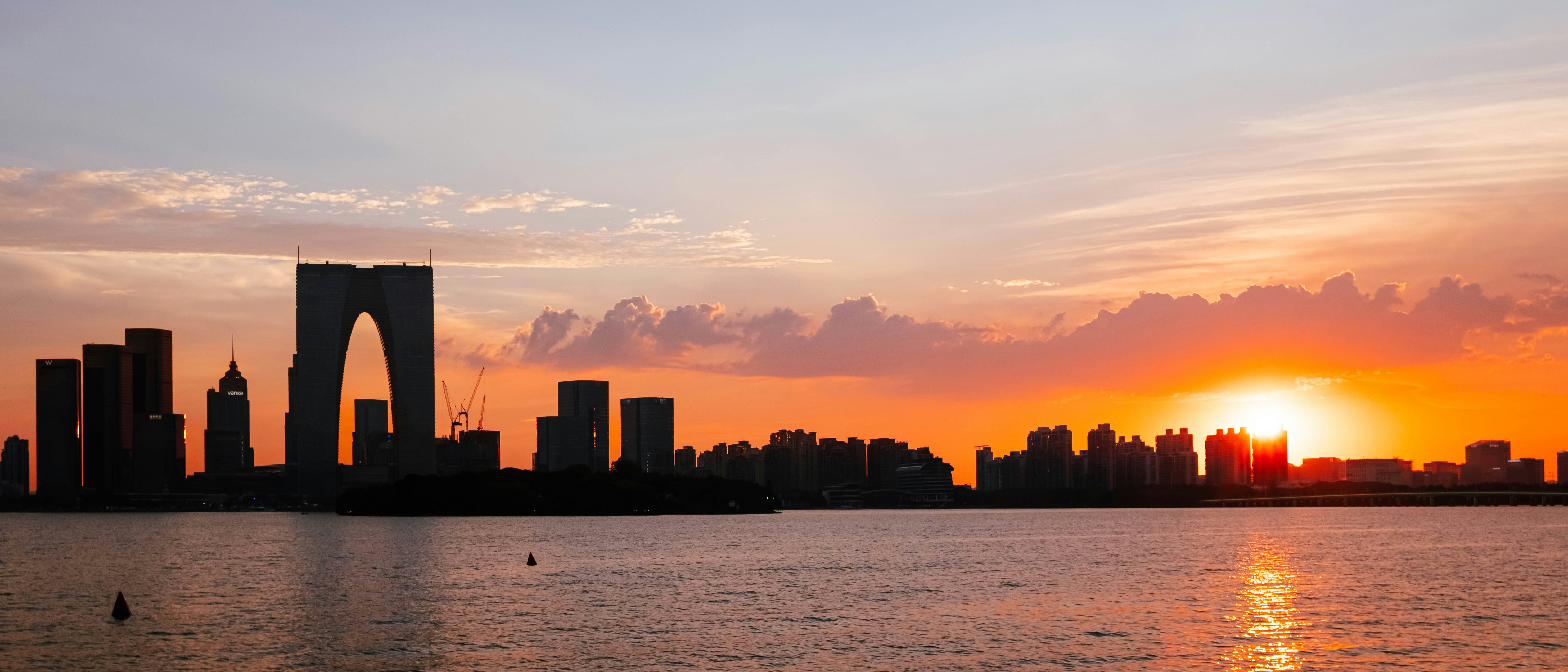 Sunset Over the Skyline: A Calm Harbor Brake with a Silhouette of Buildings