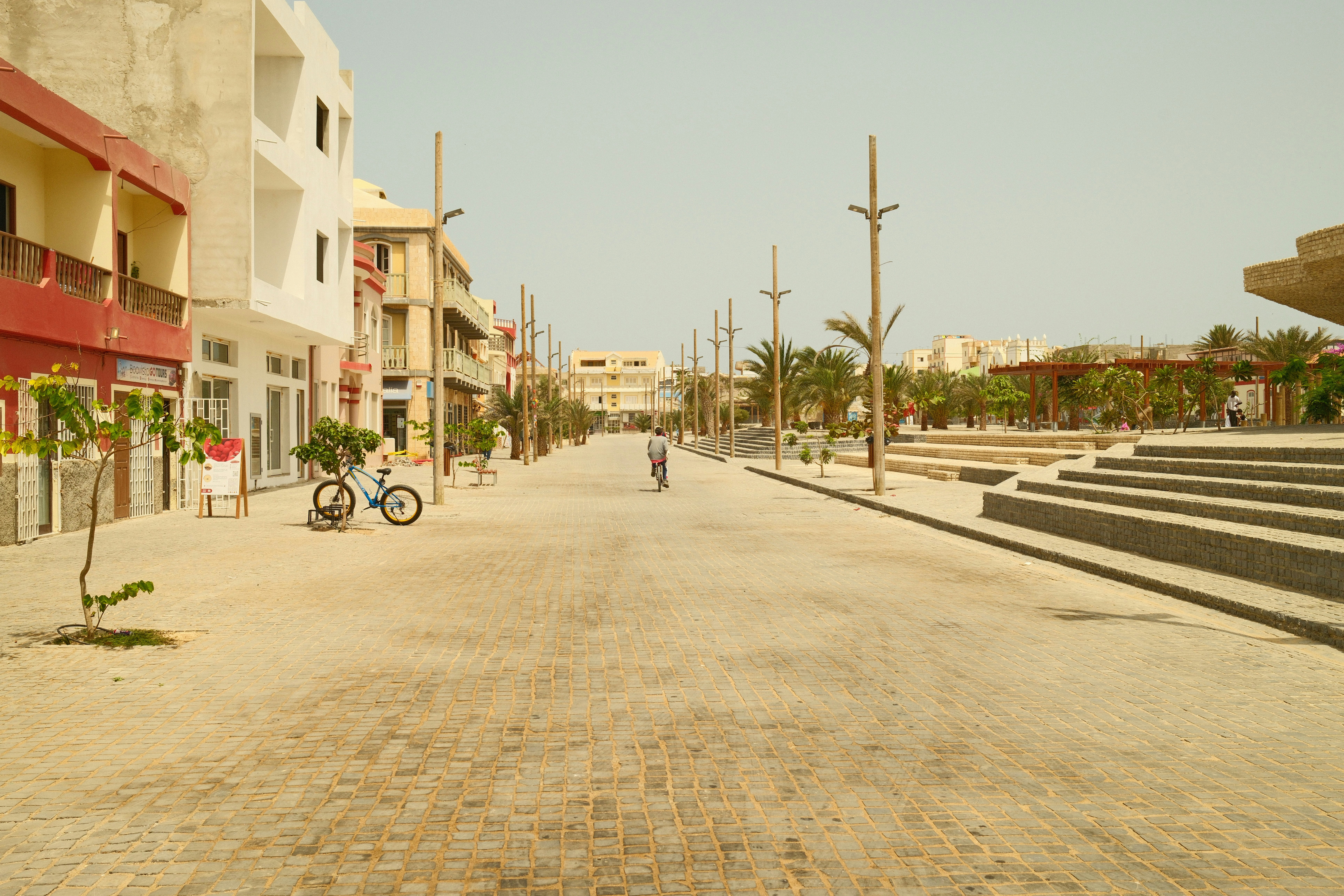 Quiet Boulevard: A Sunlit Coastal Street Gathers Pedestrians and Bicycles