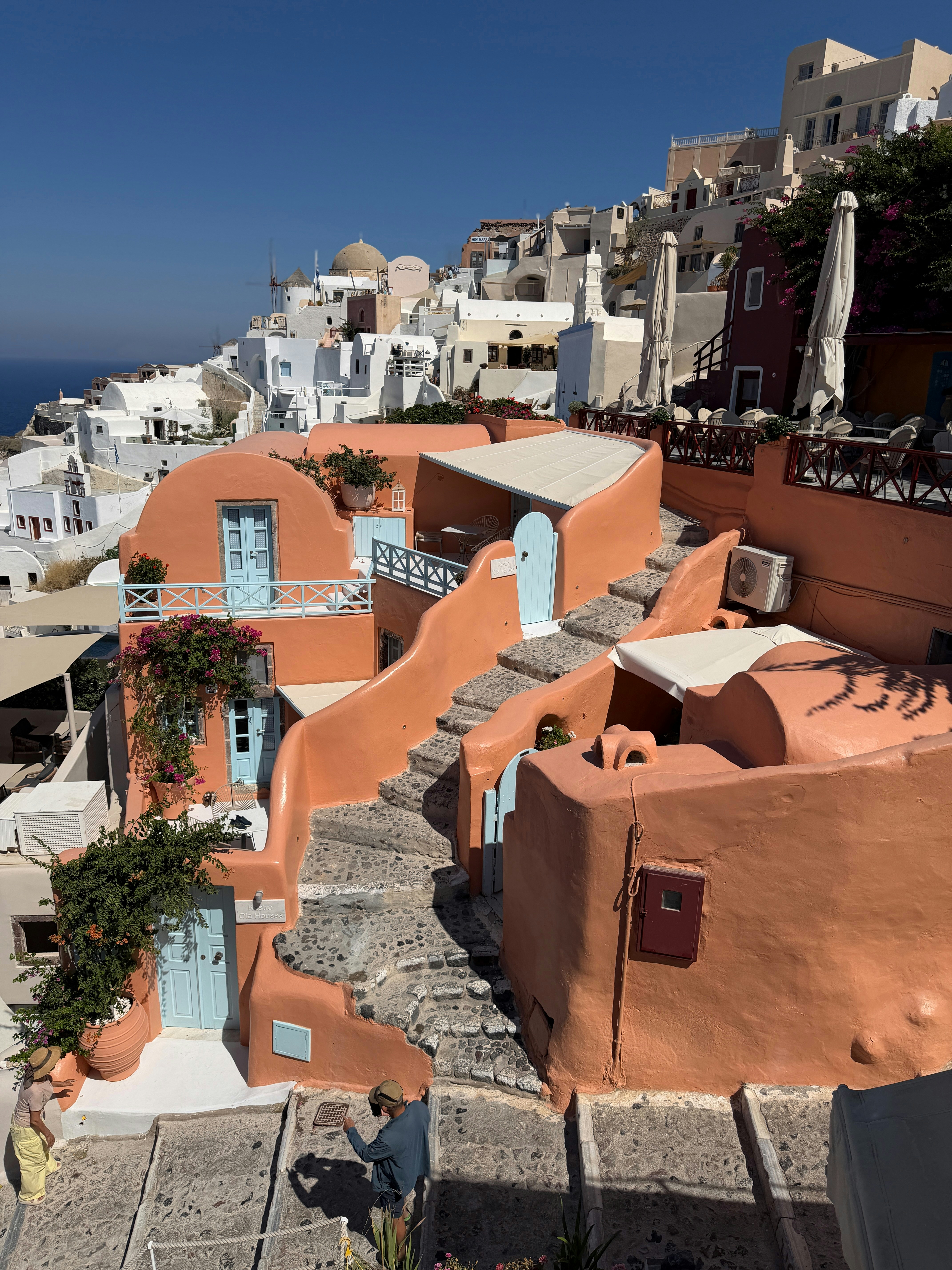Sunlit Santorini Staircase: Peach Walls and Ocean Vista