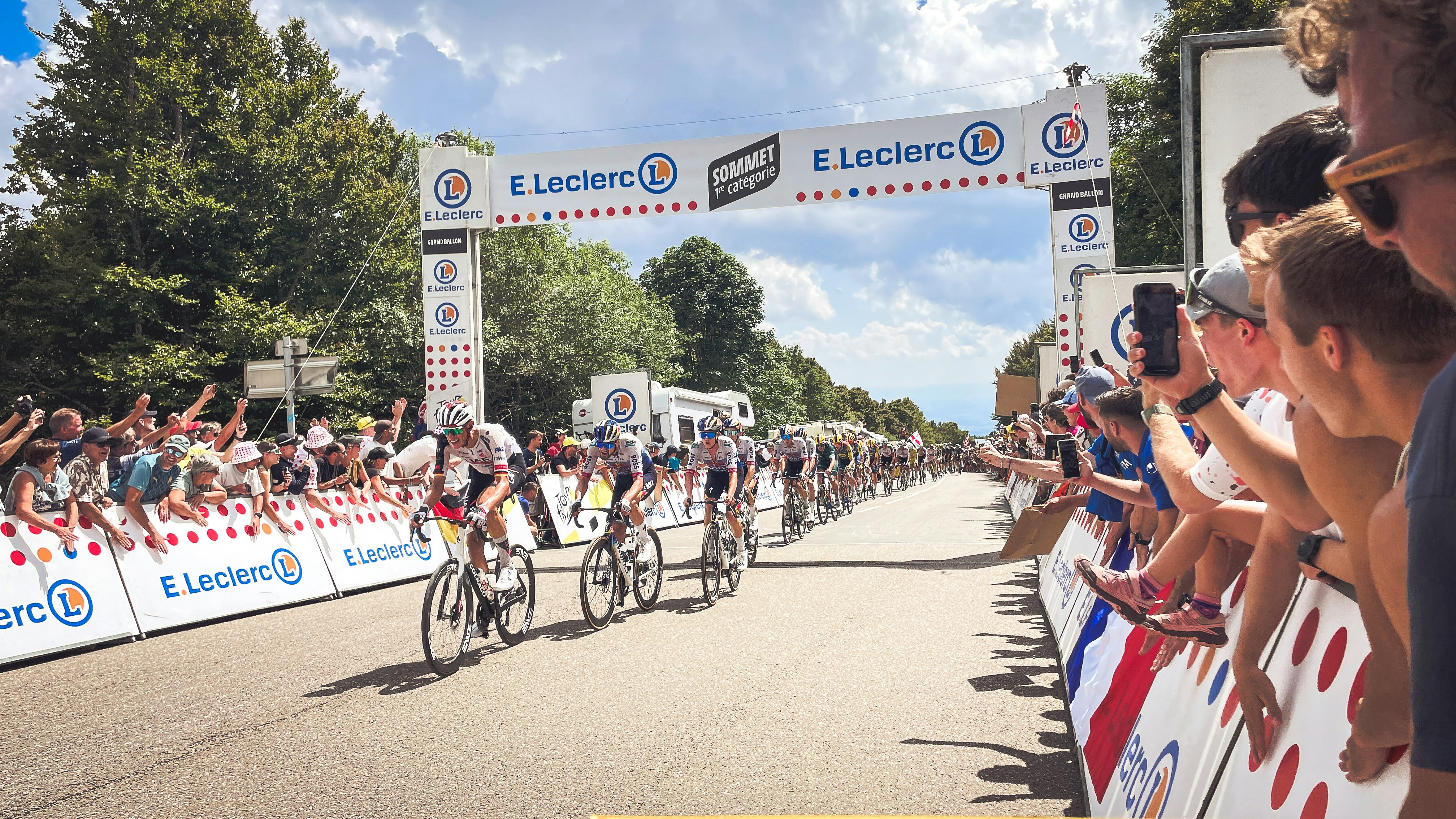 Crowd Cheers as Peloton Surges Across Finish Arch