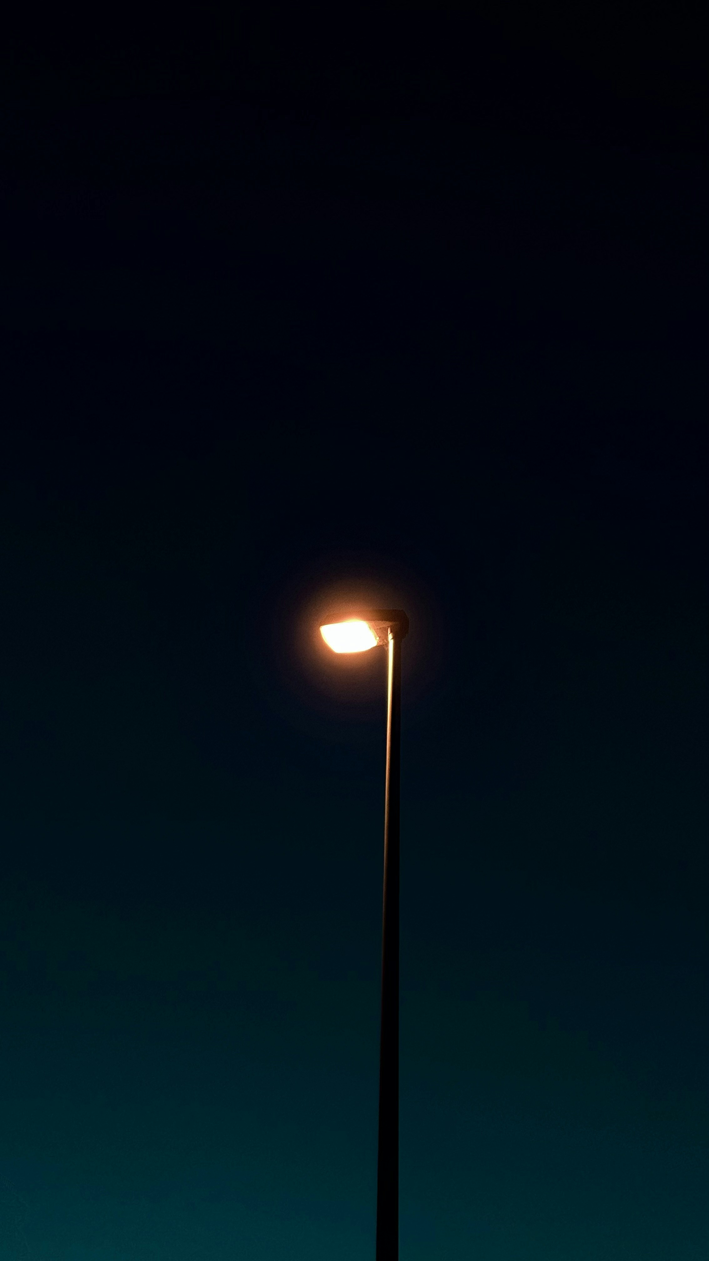 Lone Streetlight Pierces the Night's Gradient